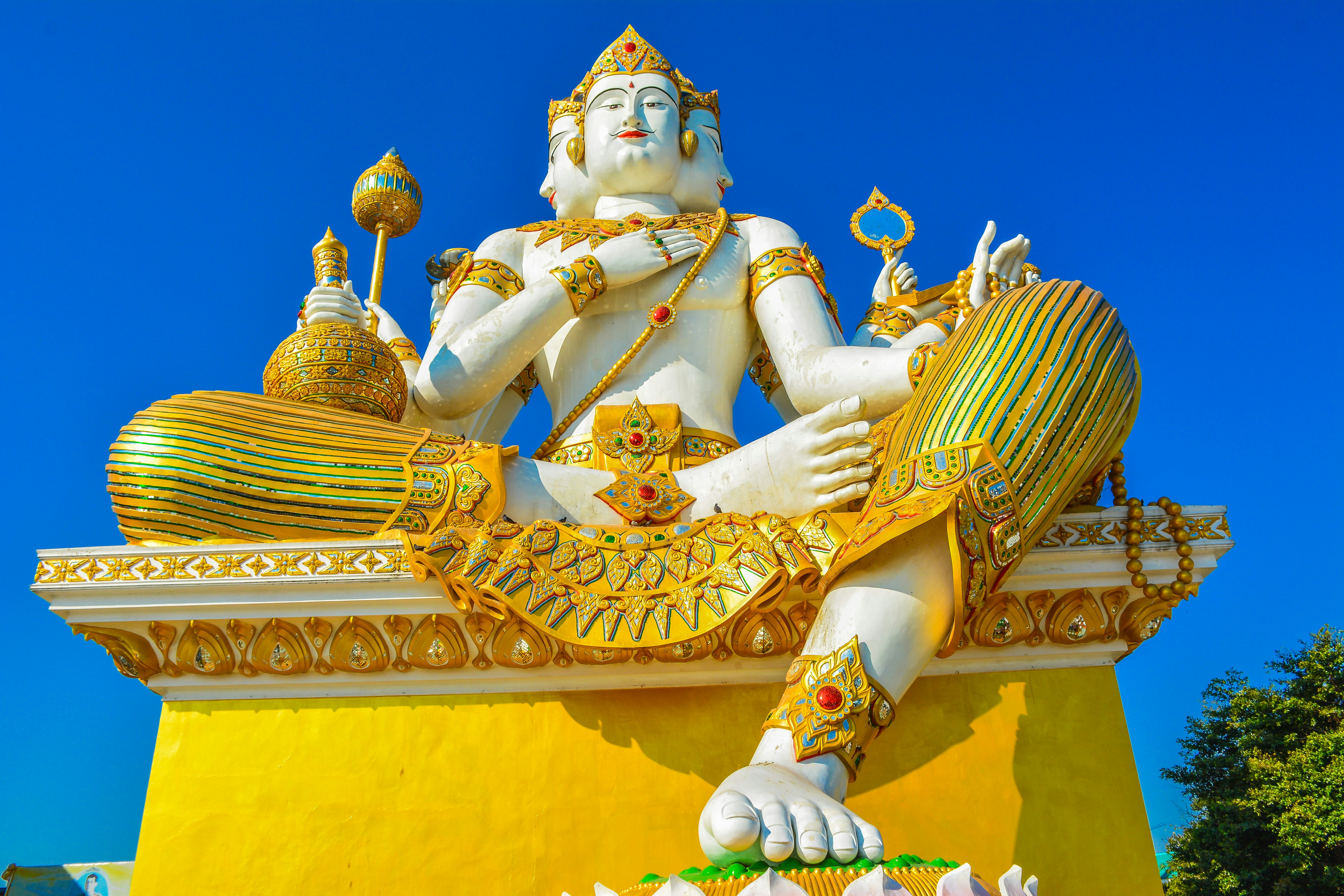 Golden Deity Silhouette: A Regal Statue Reaching Toward the Sky