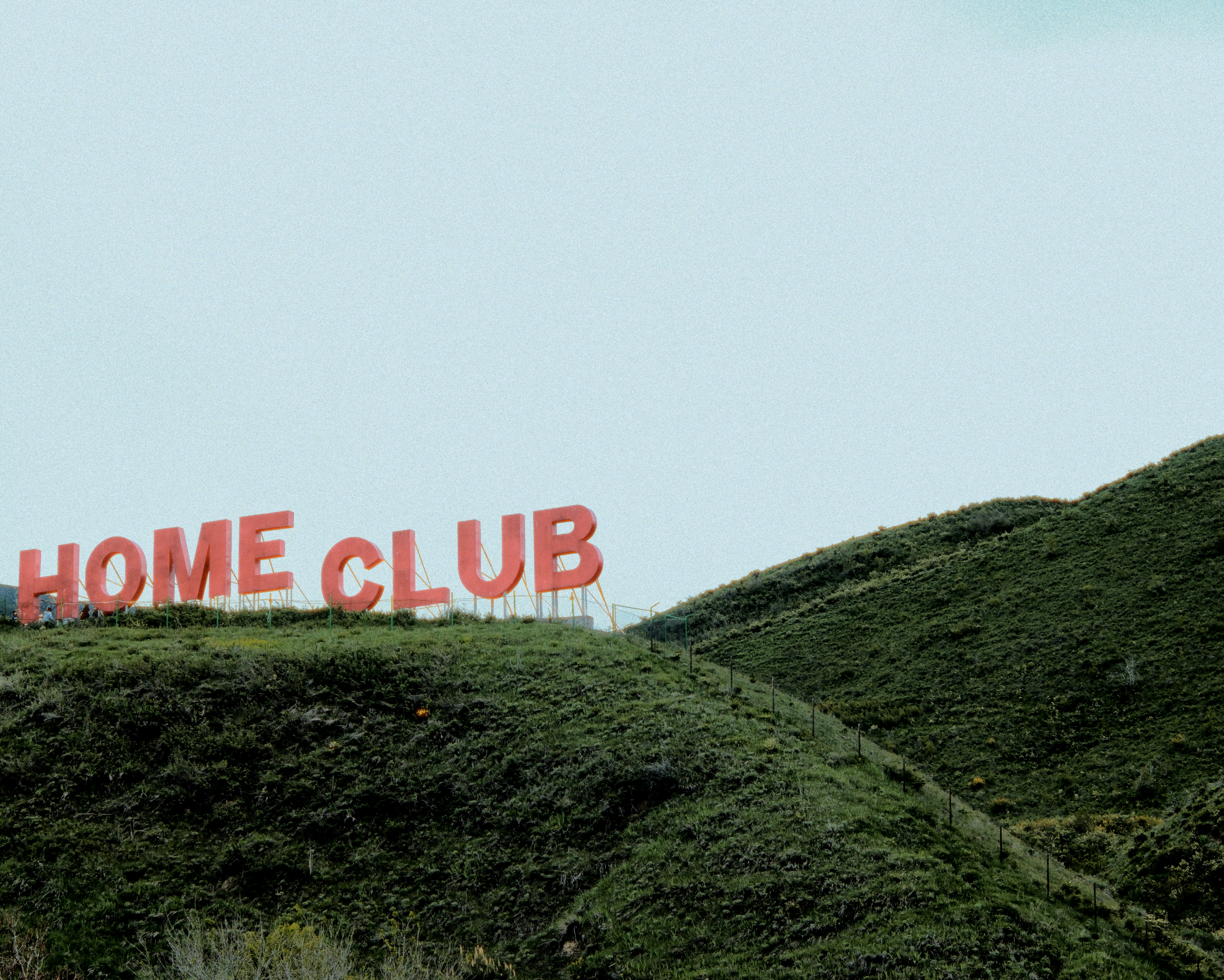 Overlooking the Home Club Sign atop a Rolling Green Hill