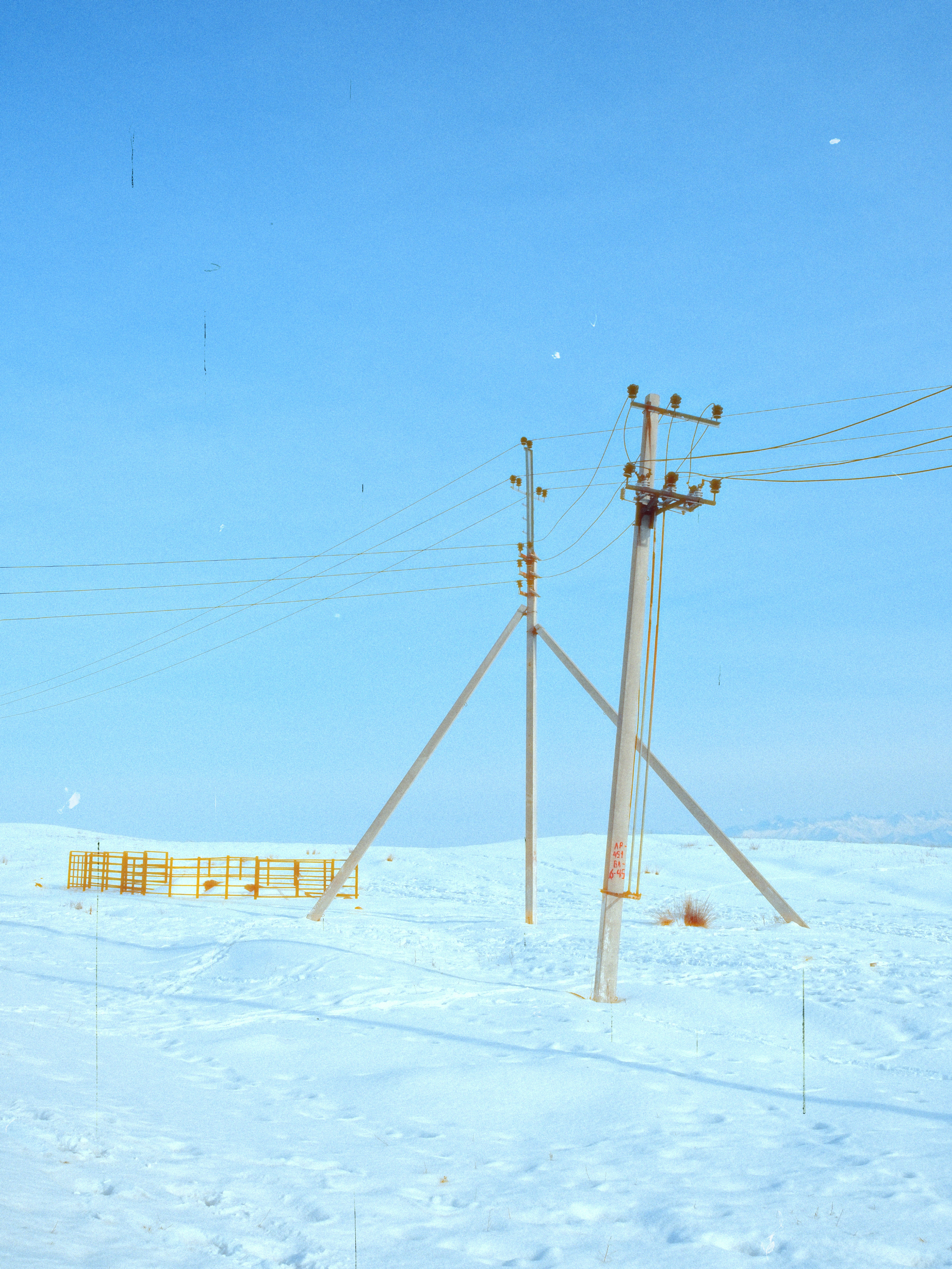 Silhouette of Power: Snowfield Pole Under Wide Sky