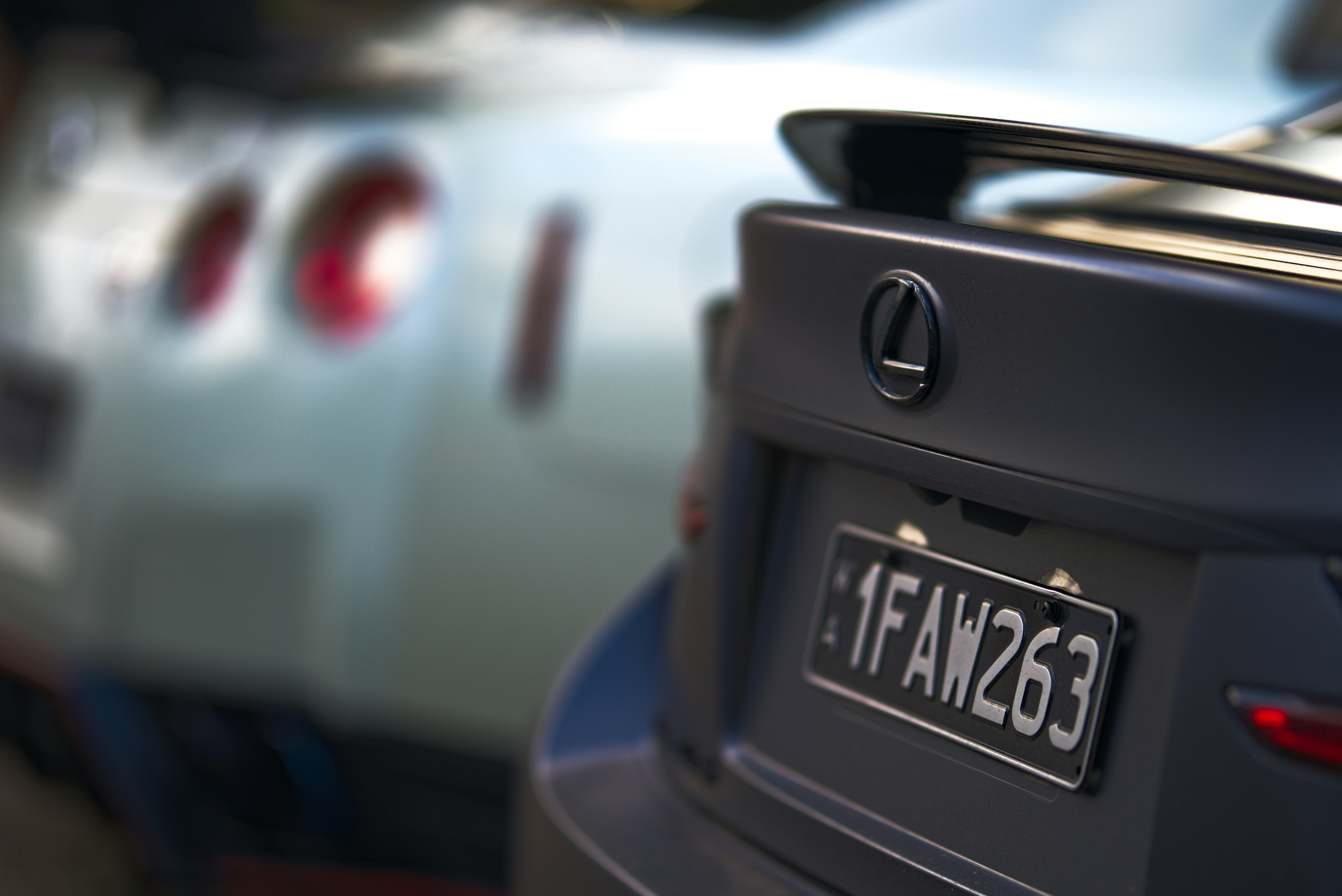 Lexus Luggage: A Car’s Emblem and Plate in Soft Focus