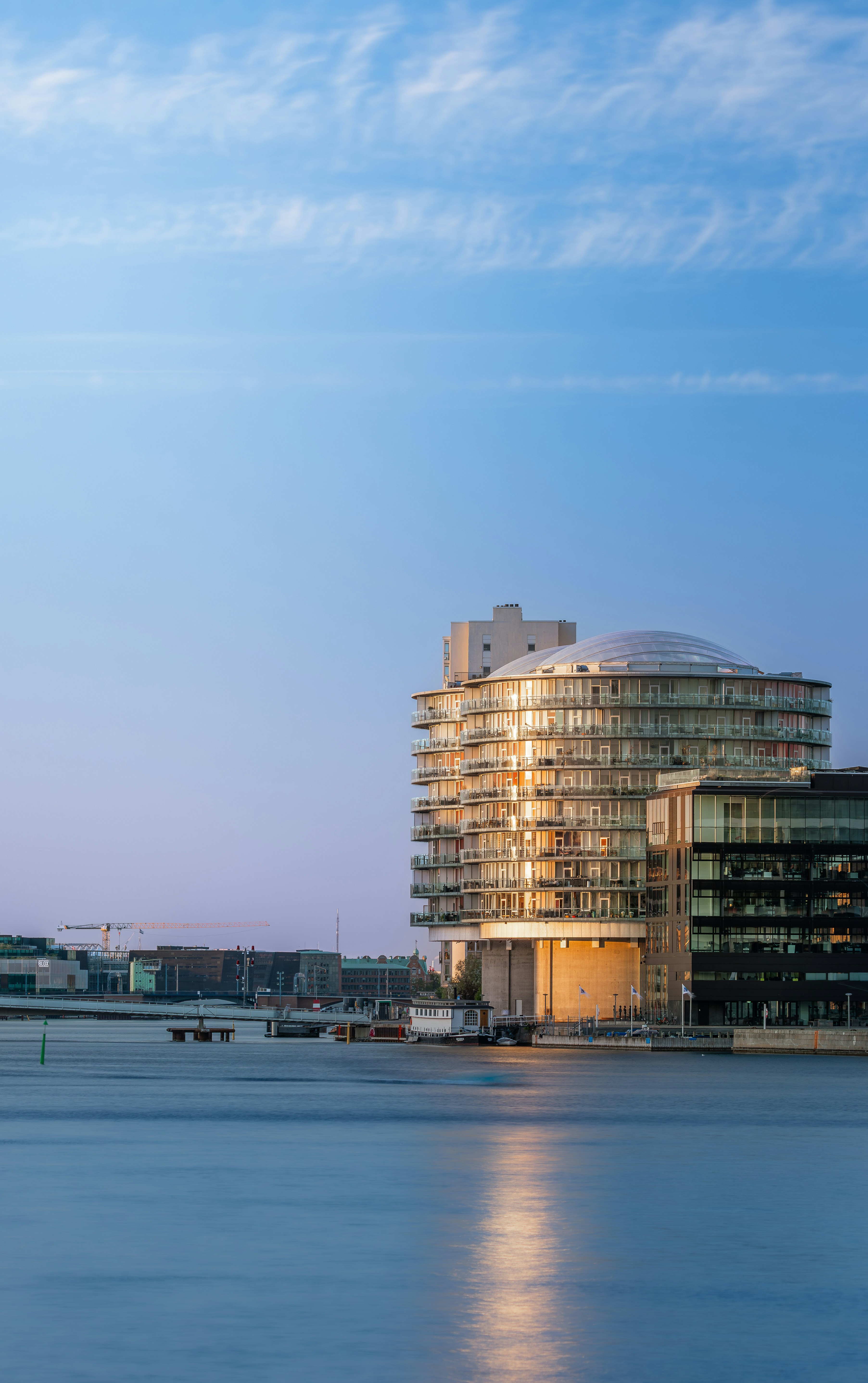 Harbor Glass: Modern building by the water at golden hour