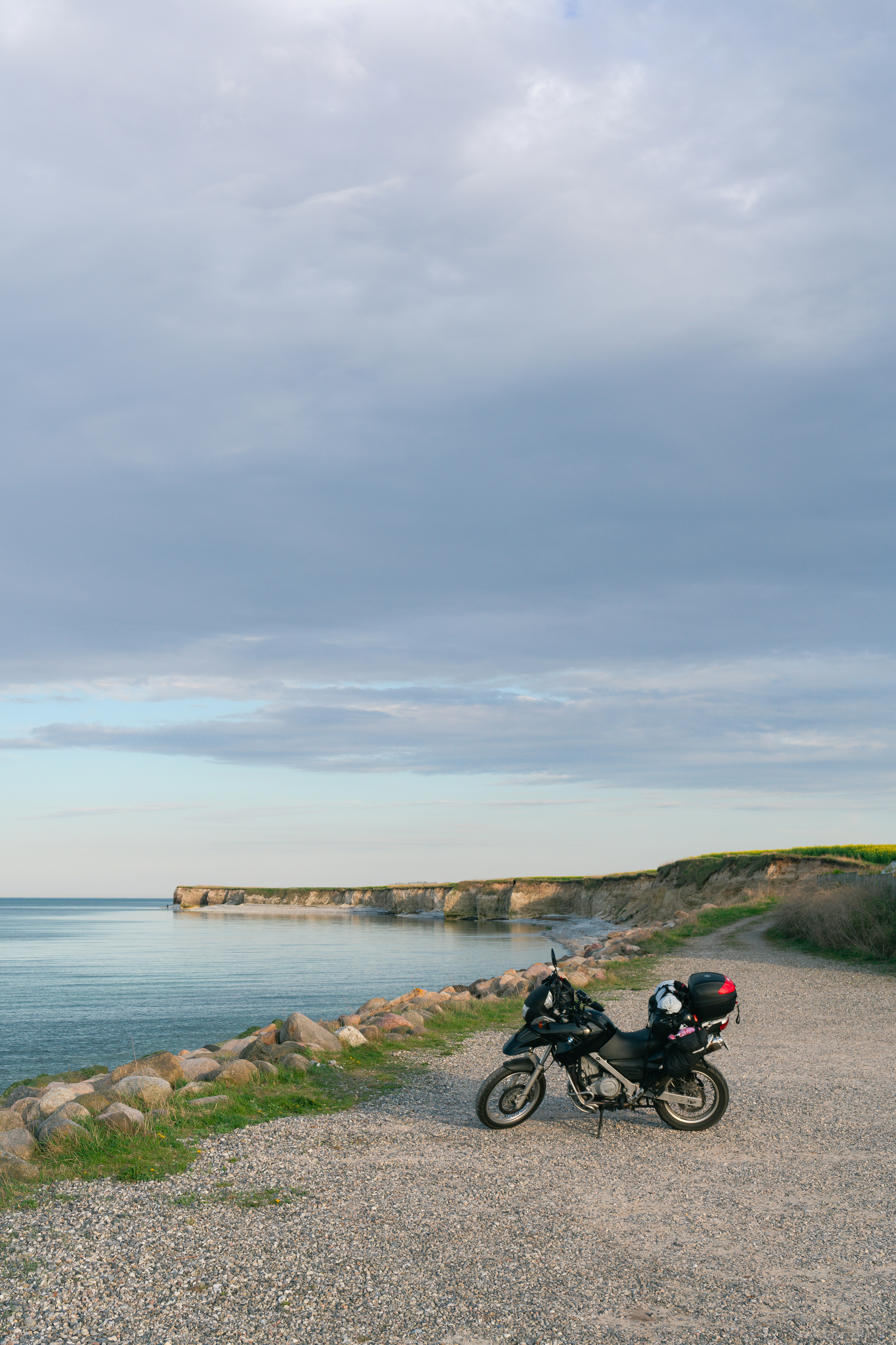 Motorcycle at the Edge: Coastal Path Under Quiet Skies
