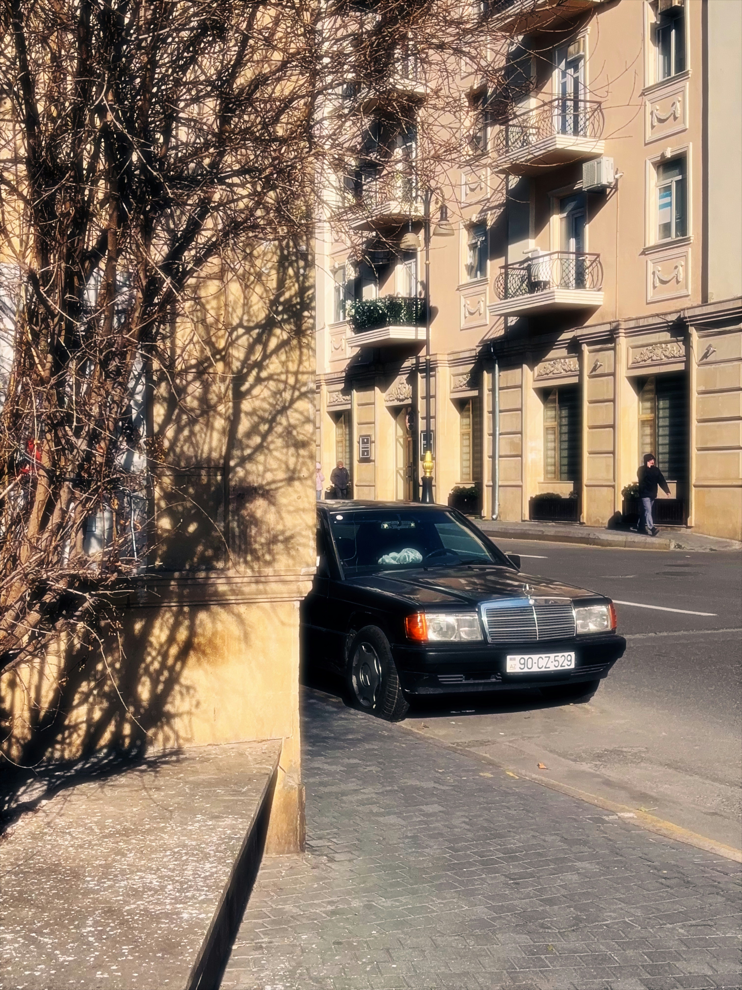 Sun-Bathed Street with a Classic Black Mercedes