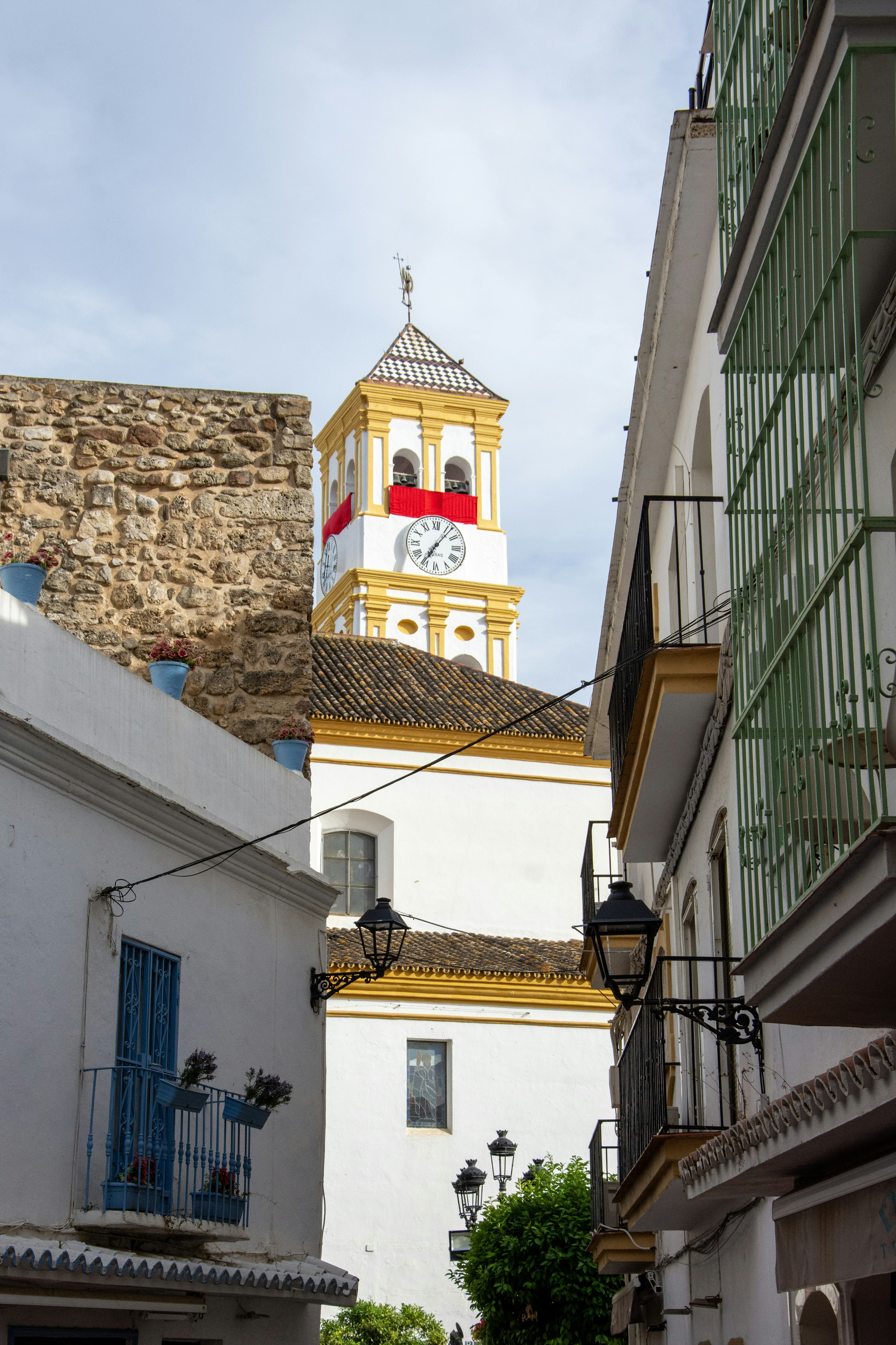 Clock tower over sunlit Andalusian street