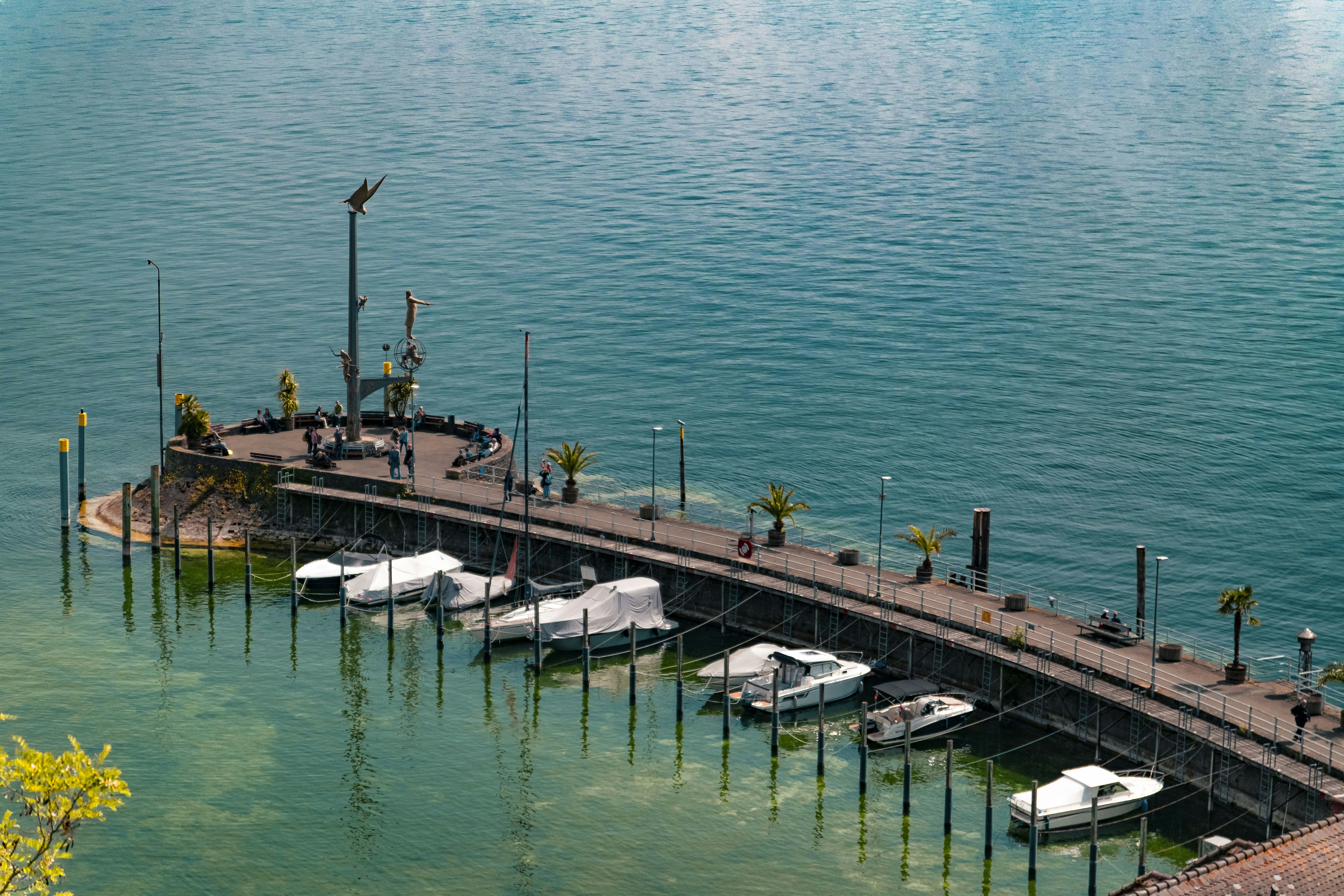 Curved Pier of Boats Adrift on Turquoise Lake
