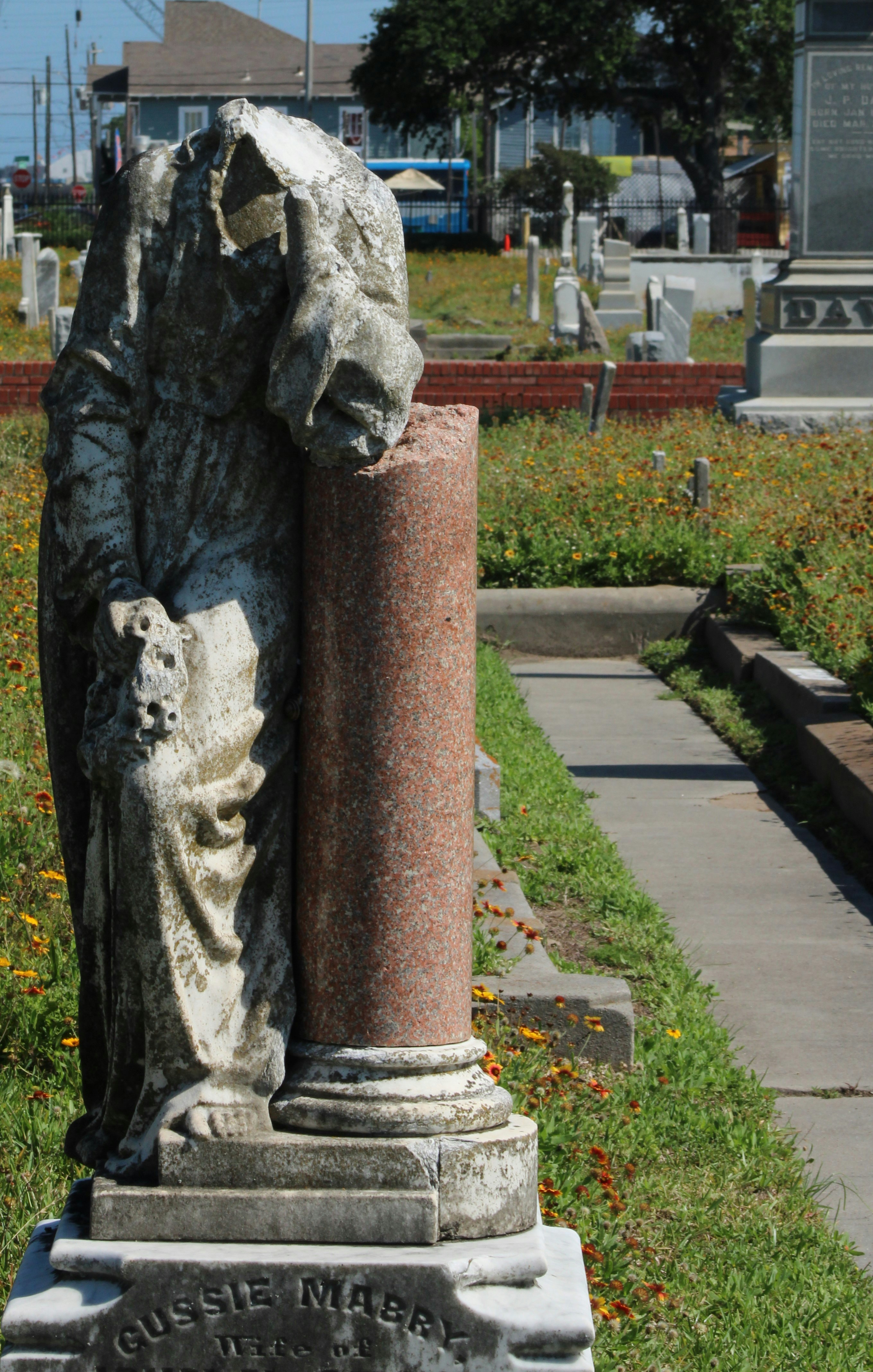 Weathered Statue Guarding a Quiet Cemetery Path