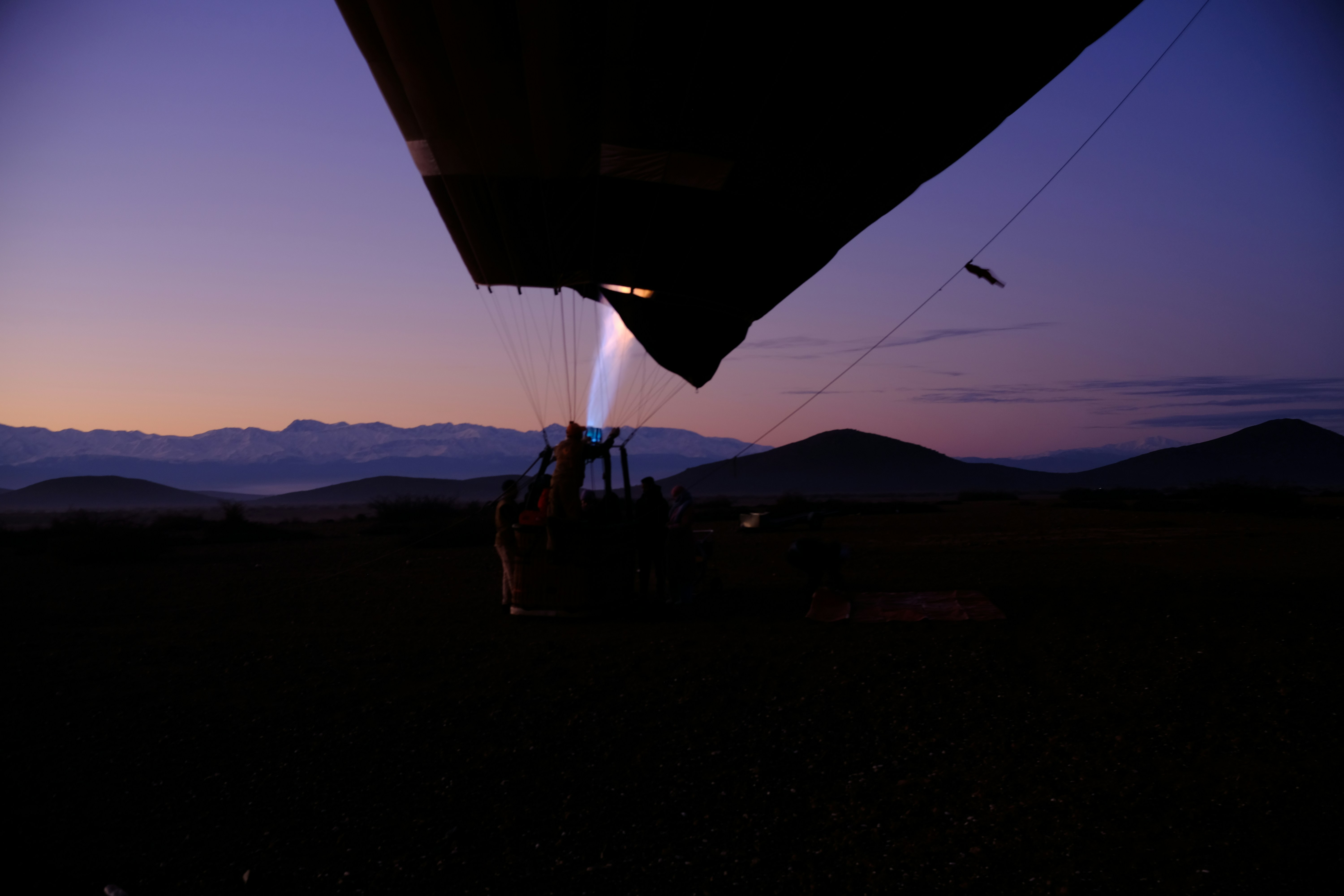 Night ascent: a paraglider powers into the violet horizon
