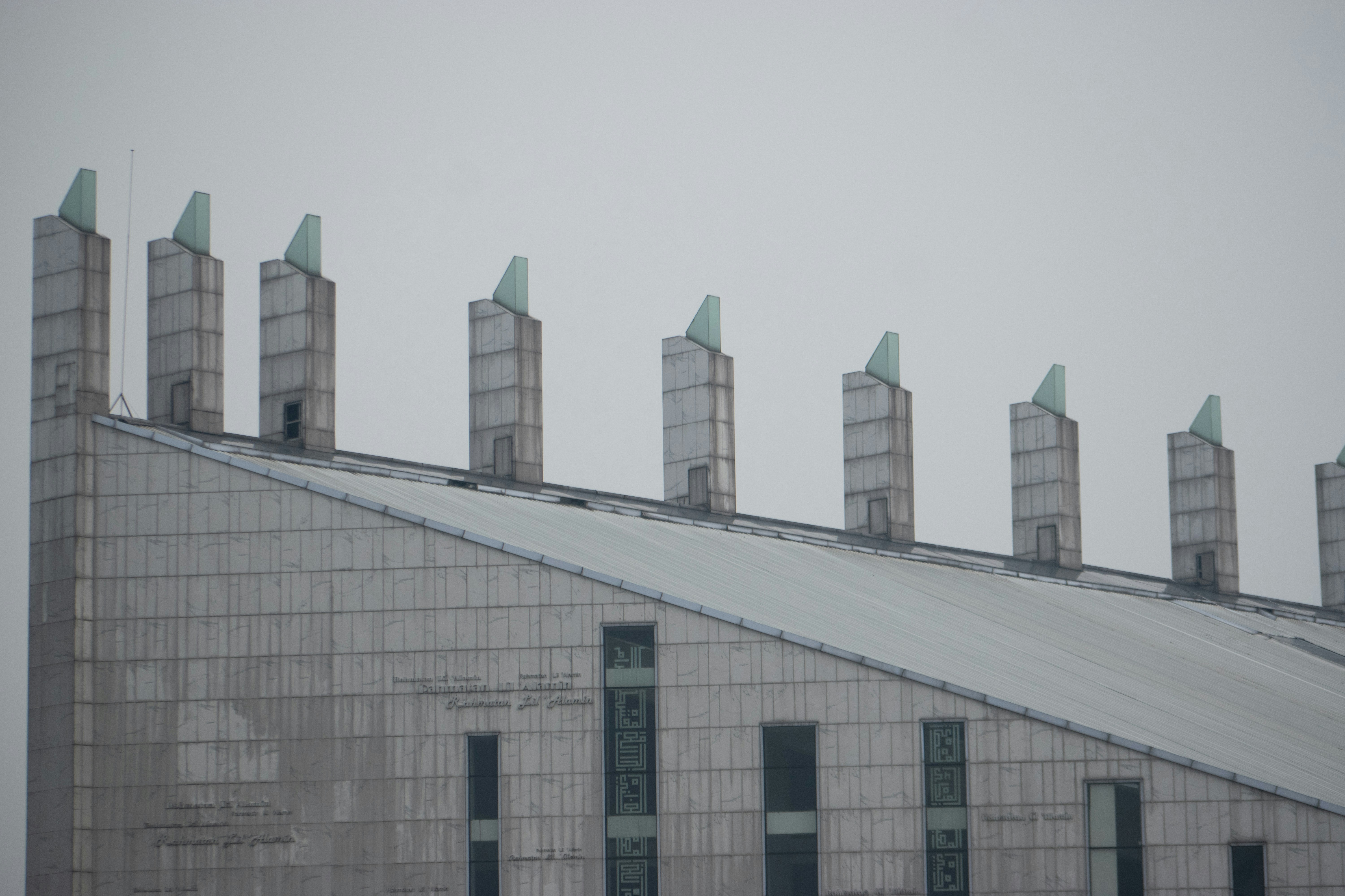 Chiseled Rooftop Ridge: Vertical Fins Against a Pale Sky