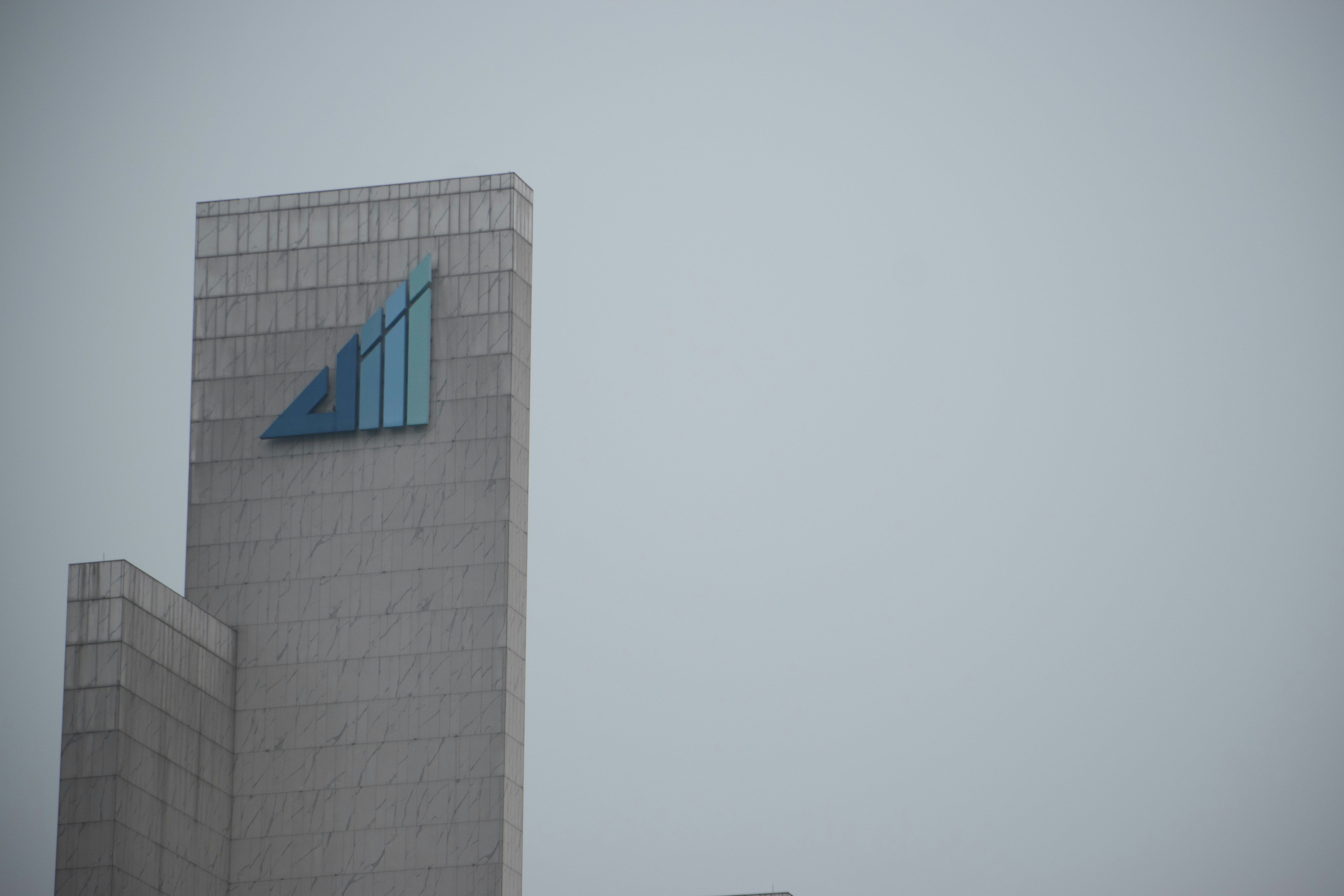 Minimalist Skyward Logo: Tall Tower with Blue Emblem