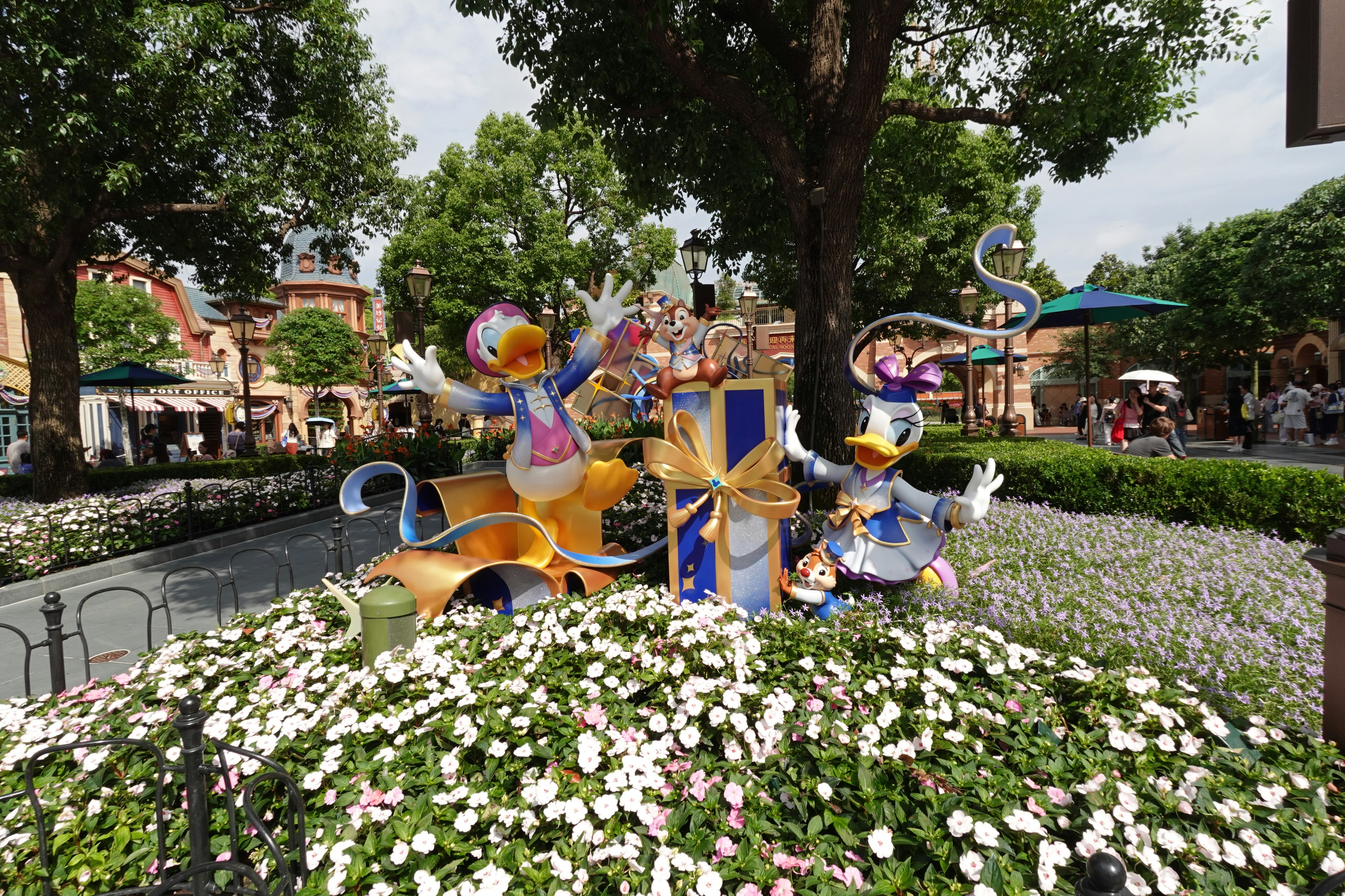 Festive donald and daisy duck display surrounded by white flowers.