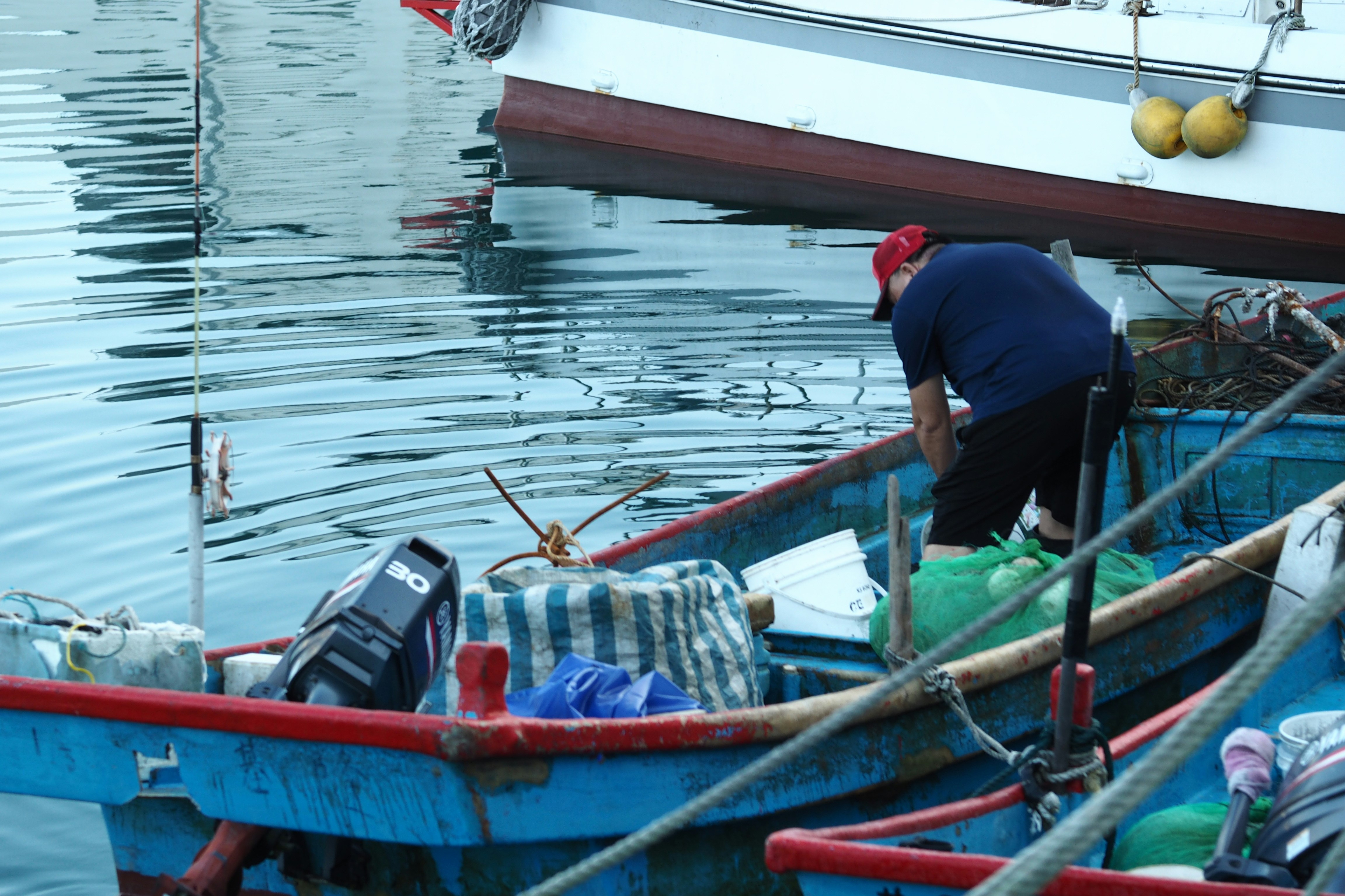 Fishing Boat Under Repair: The Red-Capped Worker at Sea