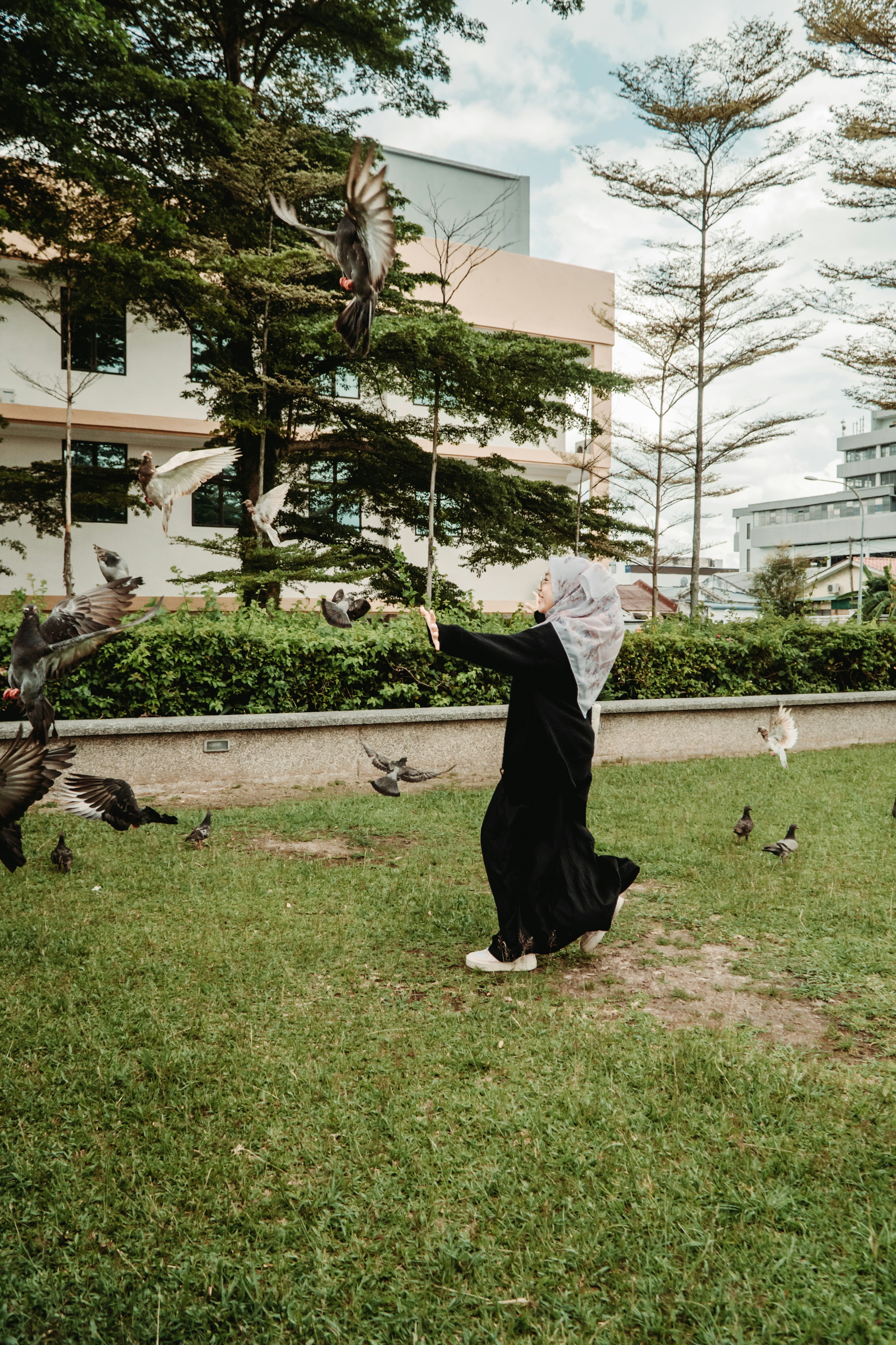Feathered Invitation: A Hijab-Clad Figure Reaches for the Sky