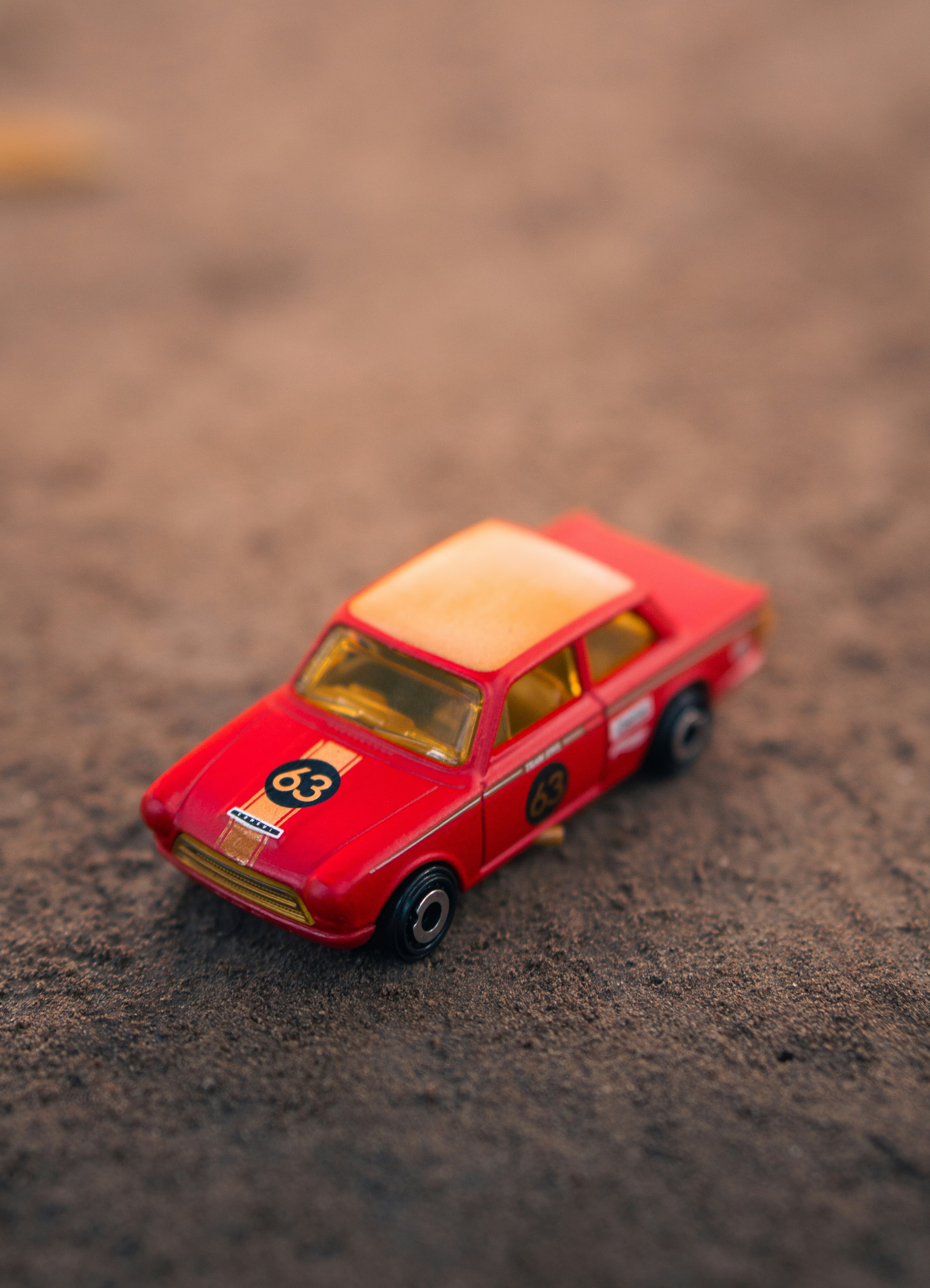Mini Red Racer: a toy car on a dusty track under soft focus