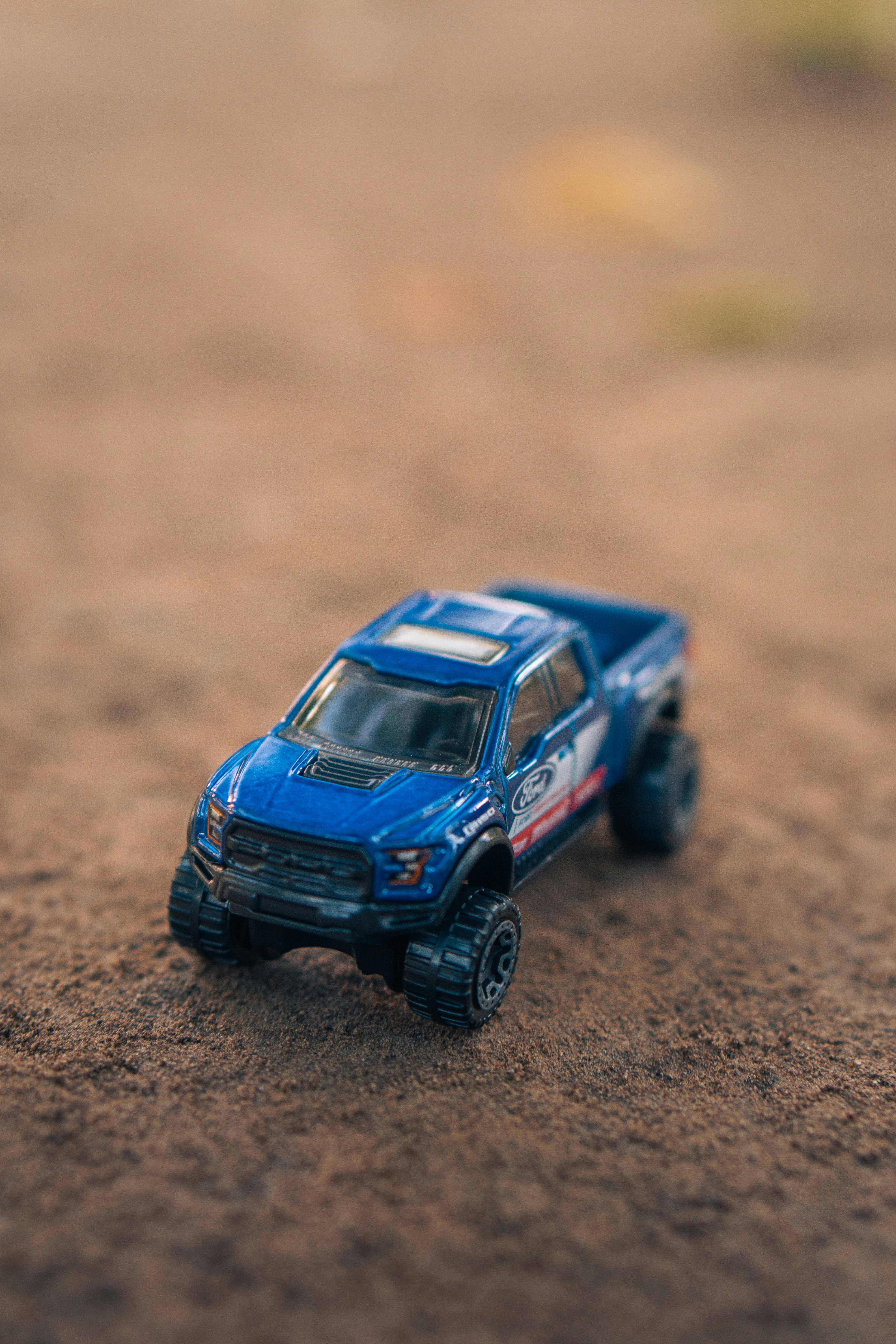 Blue off-road toy truck conquers sandy terrain