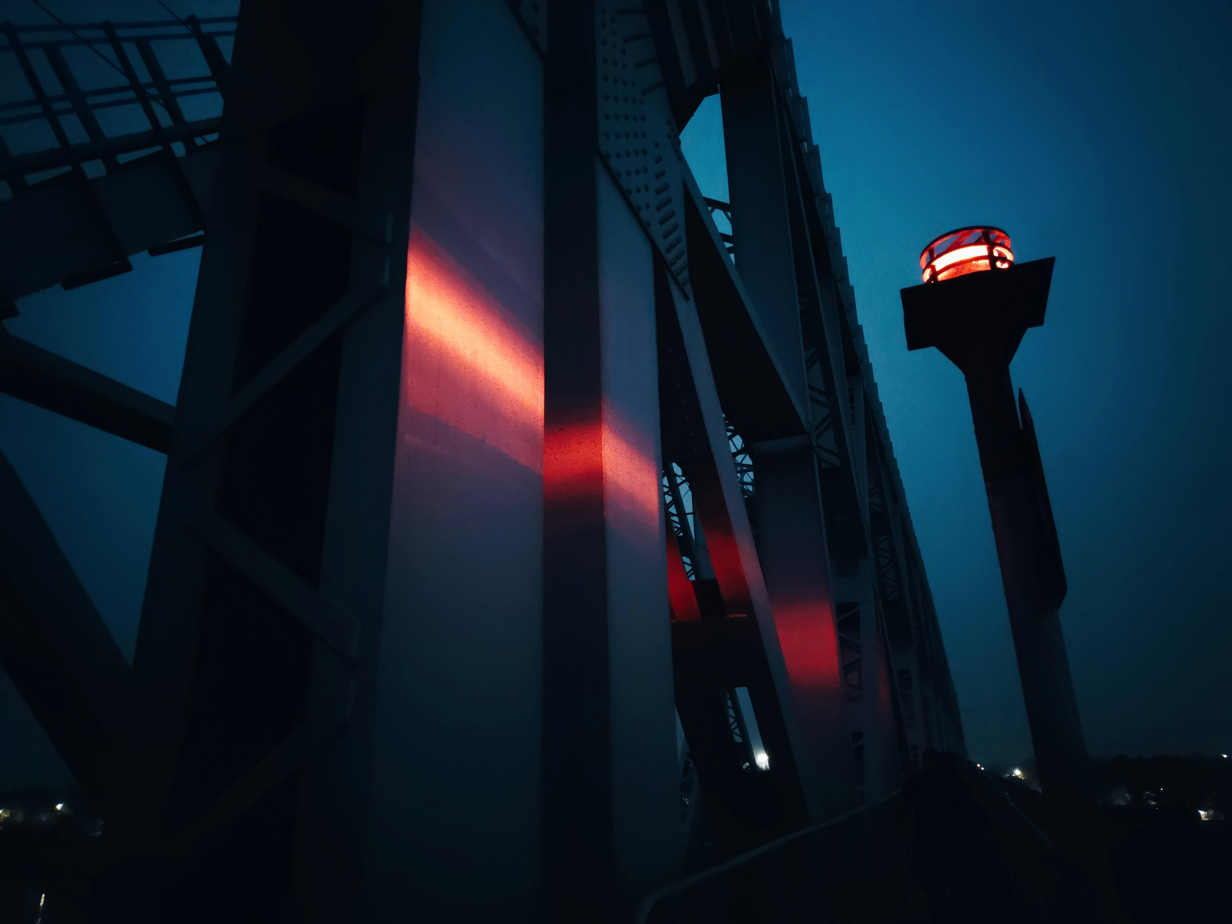 A Steel Bridge Caught in a Moody Contrast of Neon Red & Evening's Twilight Blue.