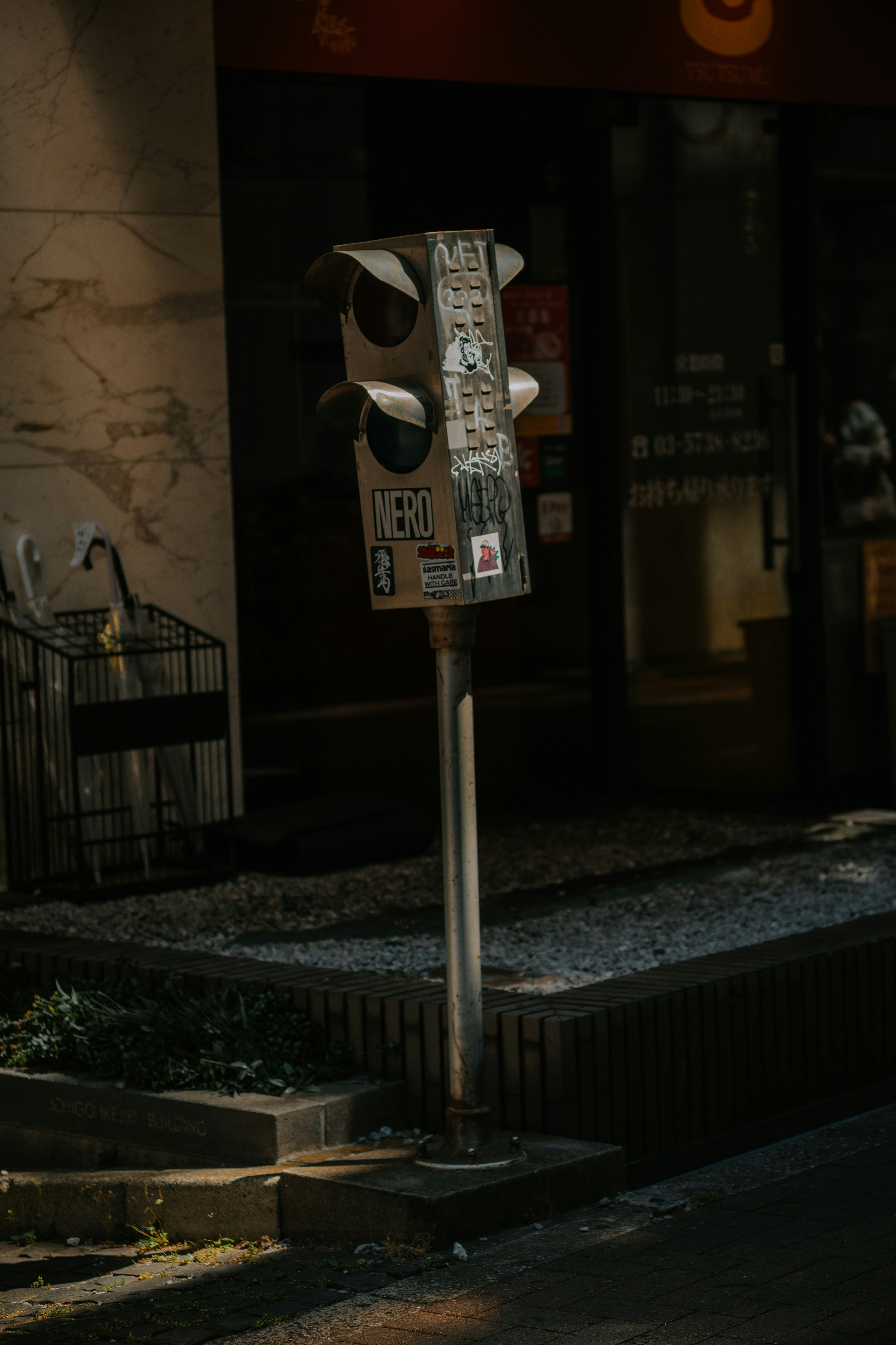 Street Corner Pedestal: Weathered Meter Board in Shadowed Facade