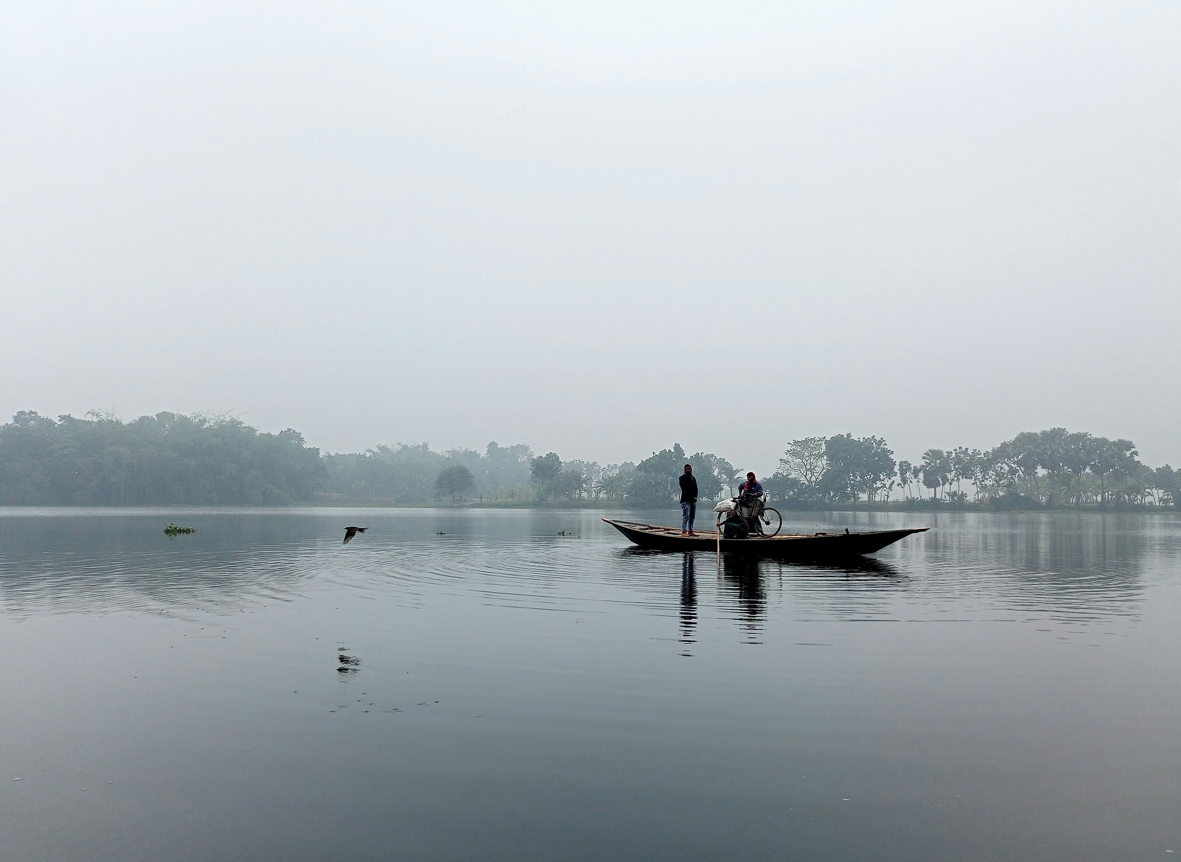 Mist on the River: A Lone Boatsman Navigates Quiet Waters