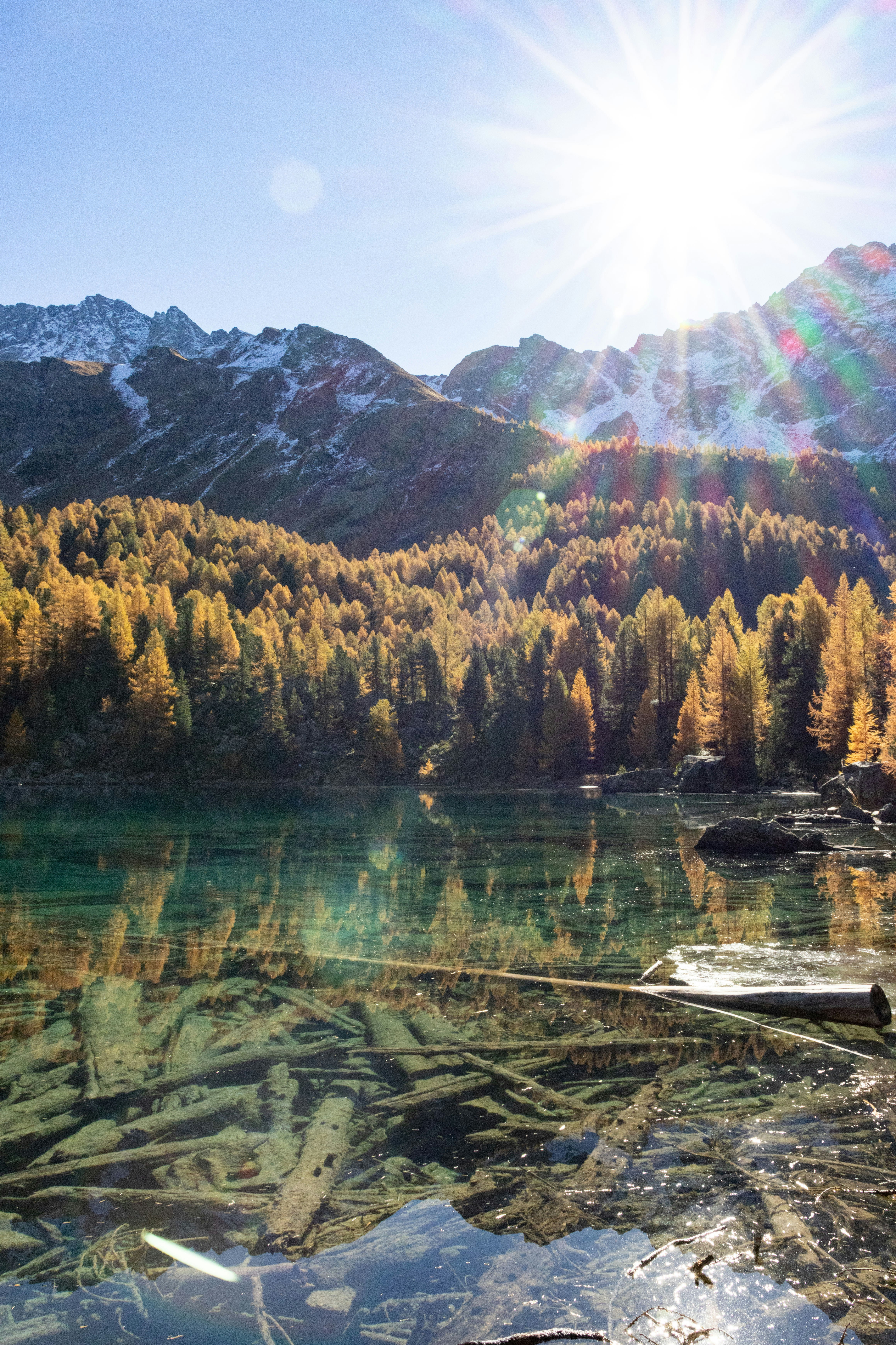Sunlit Alpine Reservoir: Reflections and Frozen Peaks