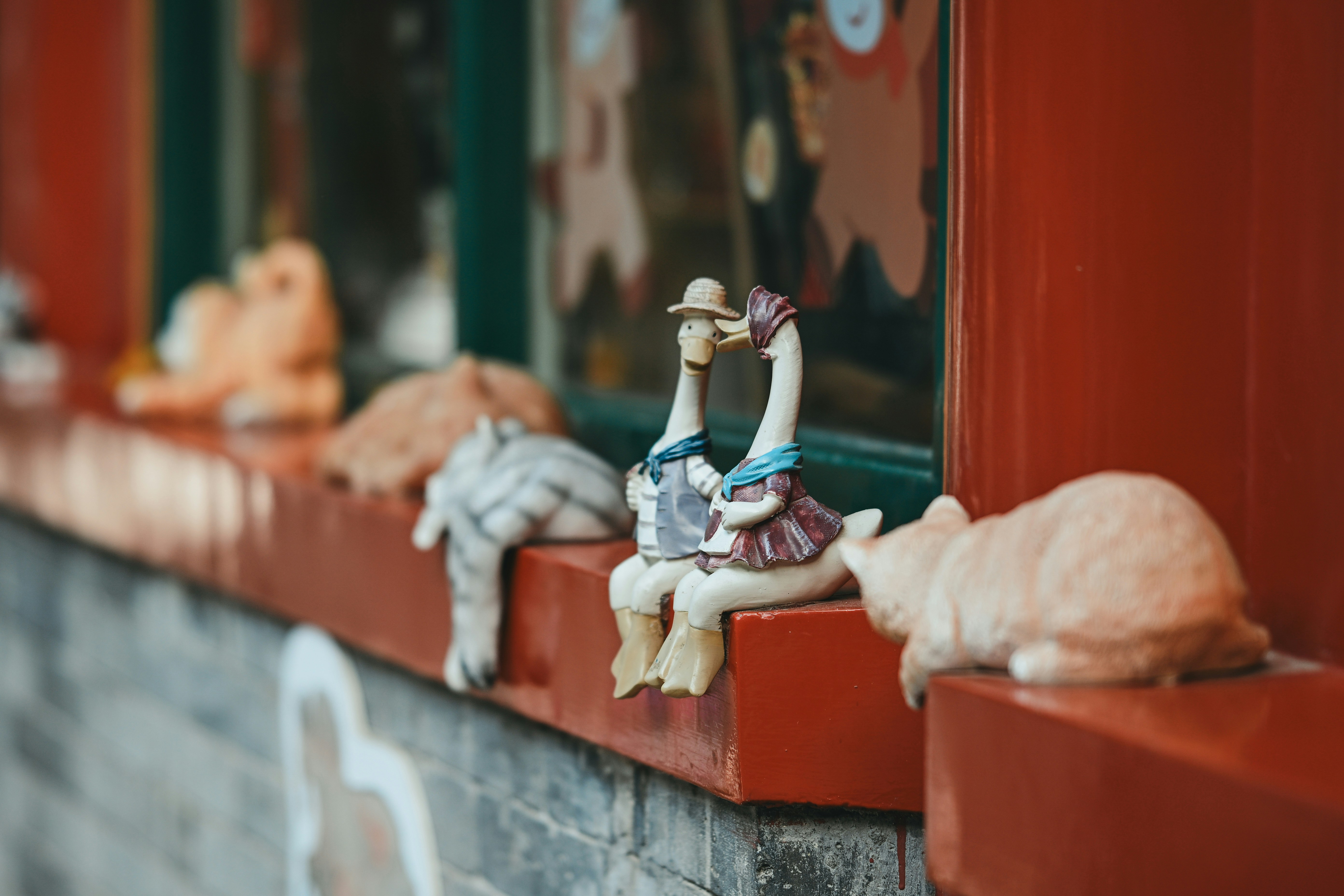 Whimsy on a Window Sill: Miniature Figures Guard the Orange Rail