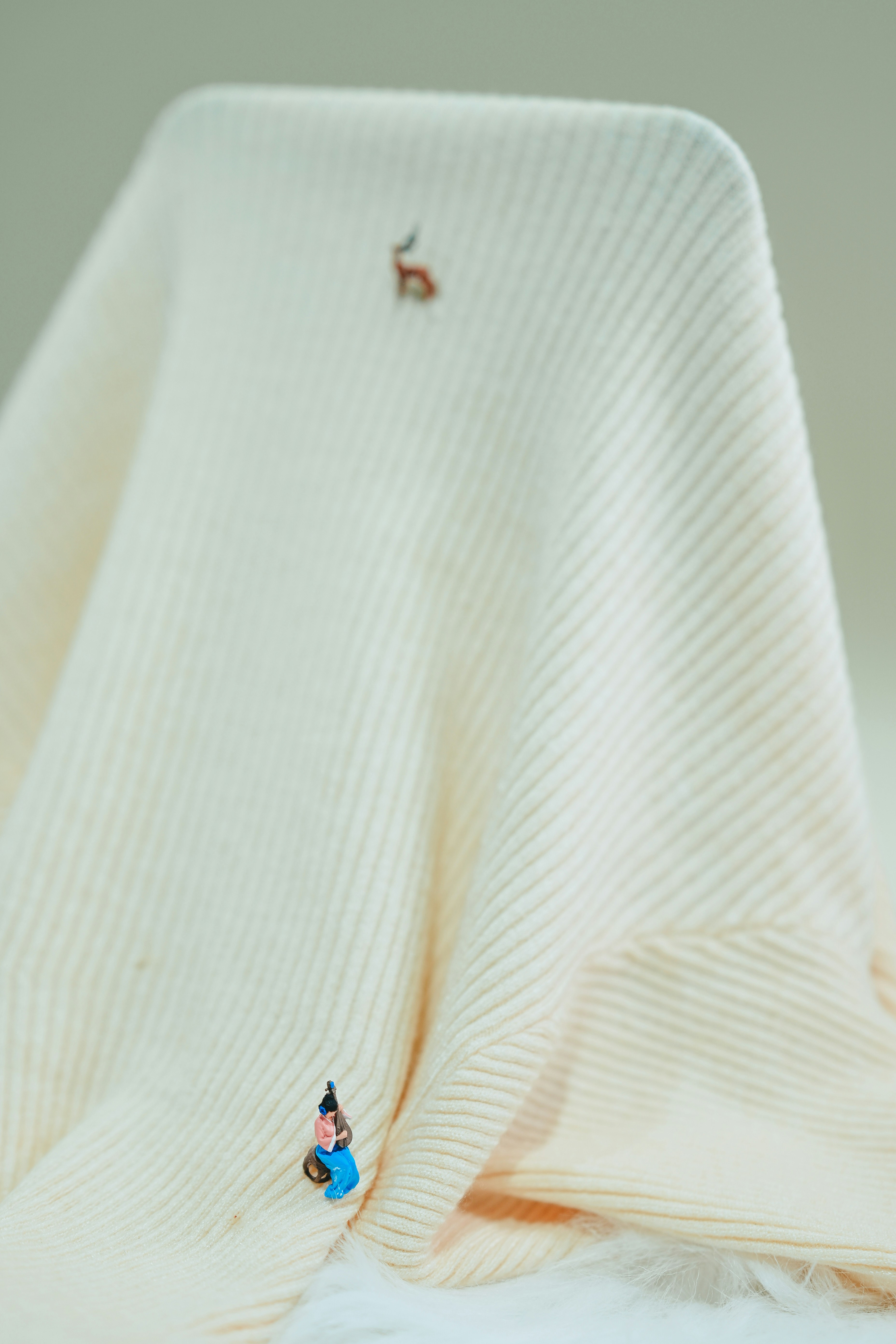 Tiny Figure, Big Curtain: A Whimsical Scene on a Soft Mantle