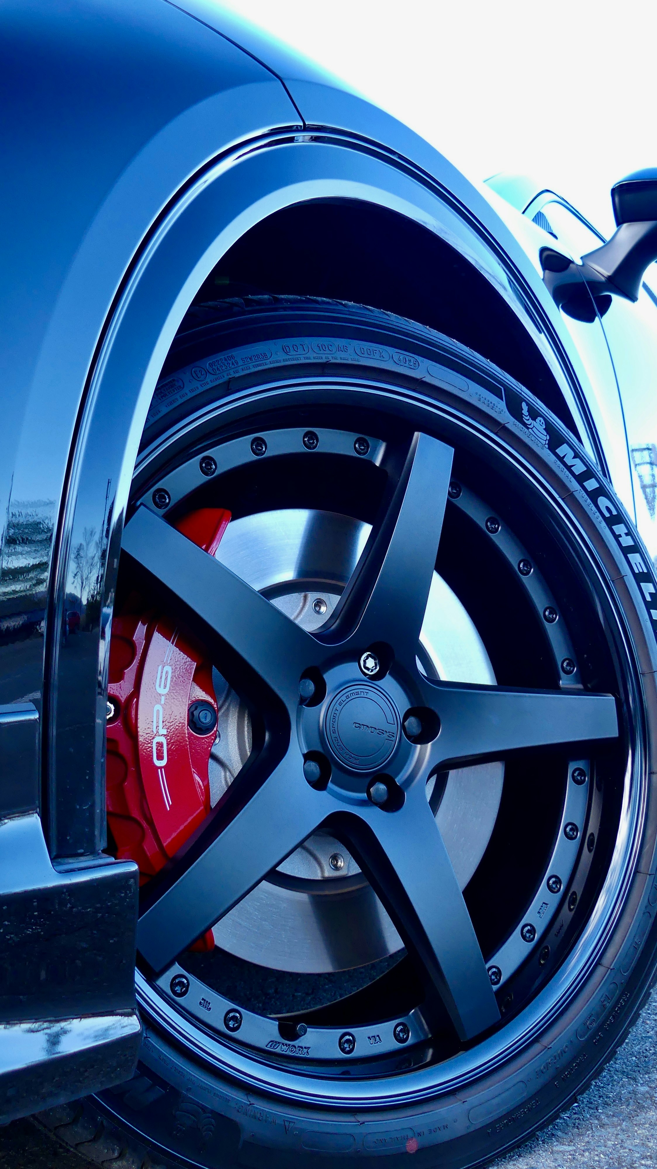 High-Performance Rim: A close-up of a blue sports wheel and red brake caliper