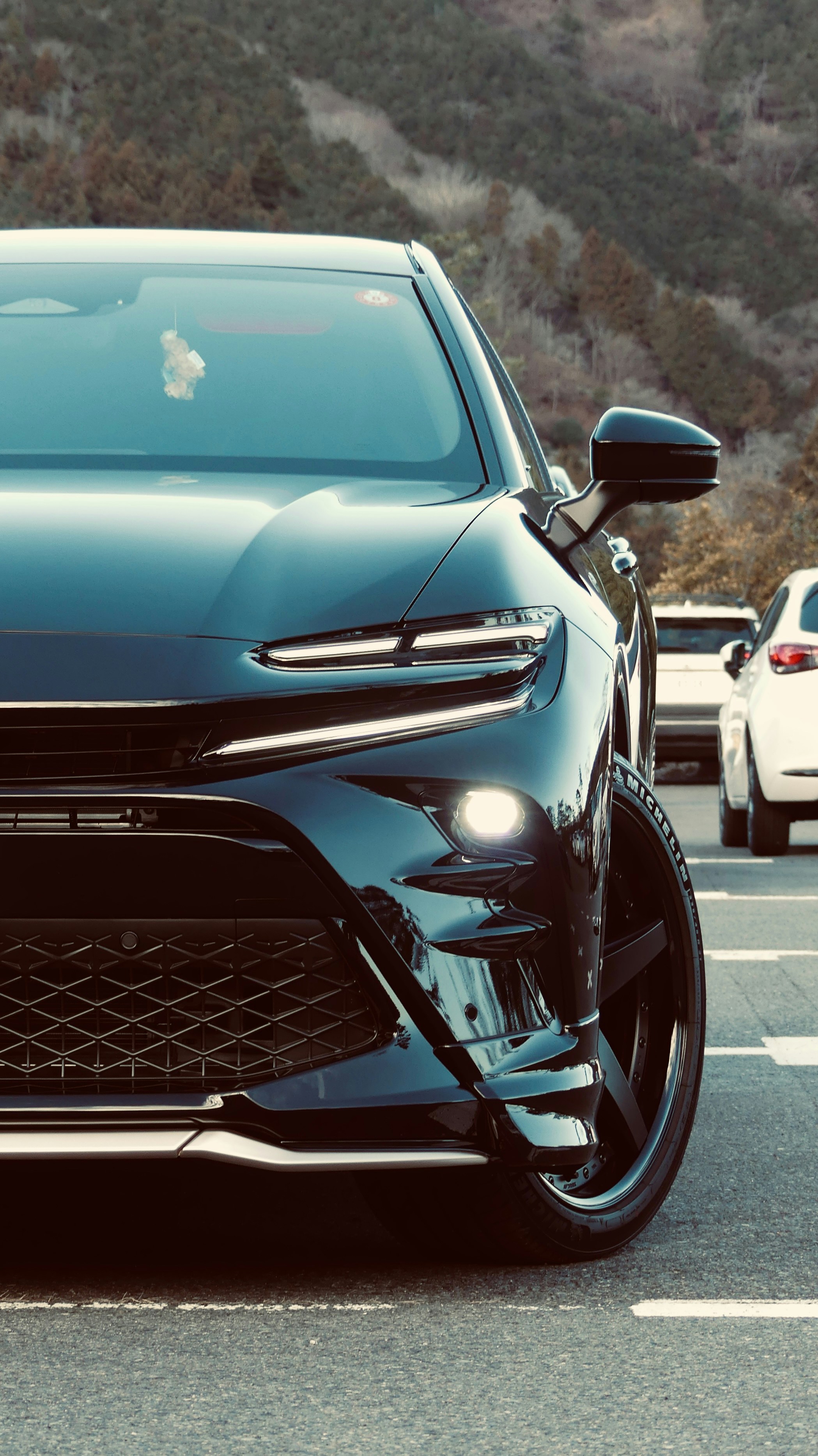 Front-Quarter Power: A Sleek Black Beast in a Sunlit Parking Lot