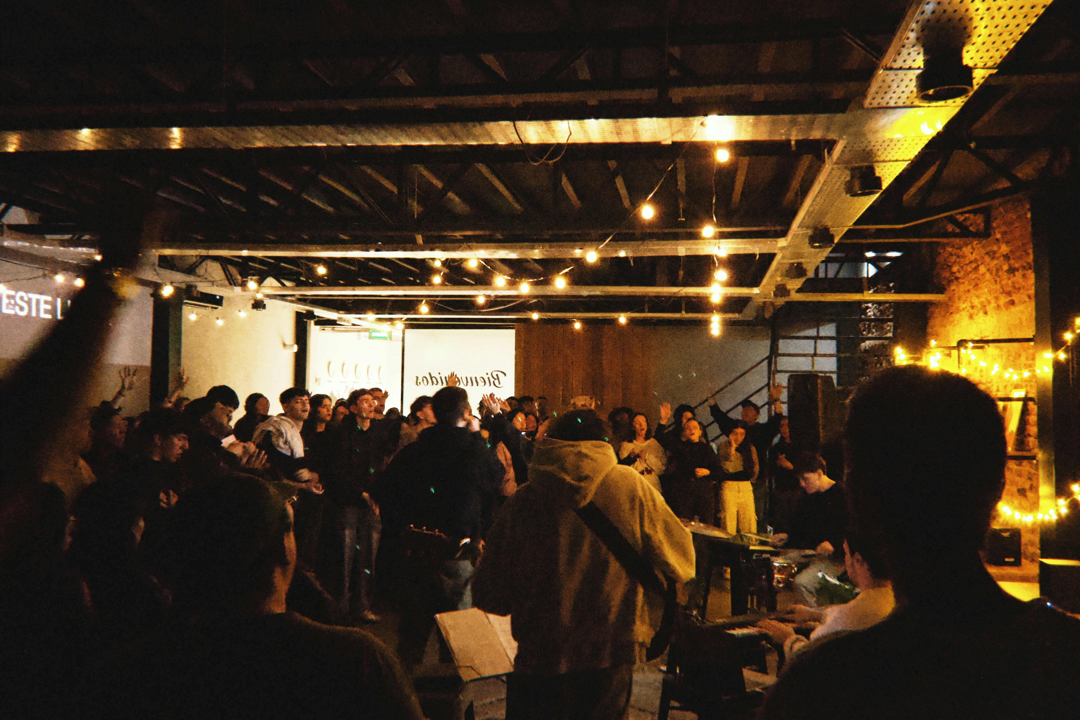 Crowd Surrounded by Warm Lights at a Dim Indoor Event