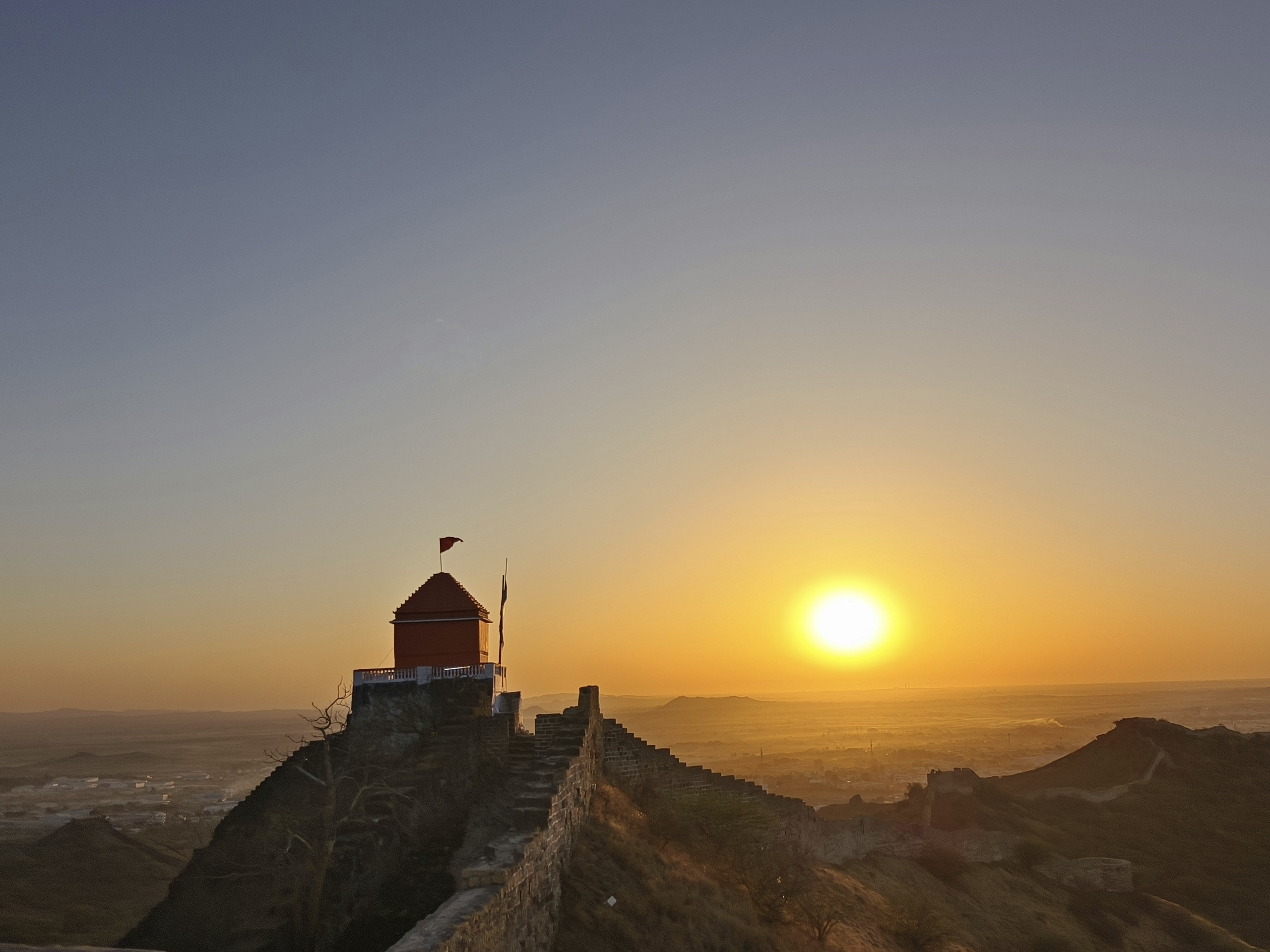 Sunlit beacon atop a cliff: a coastal sunset scene