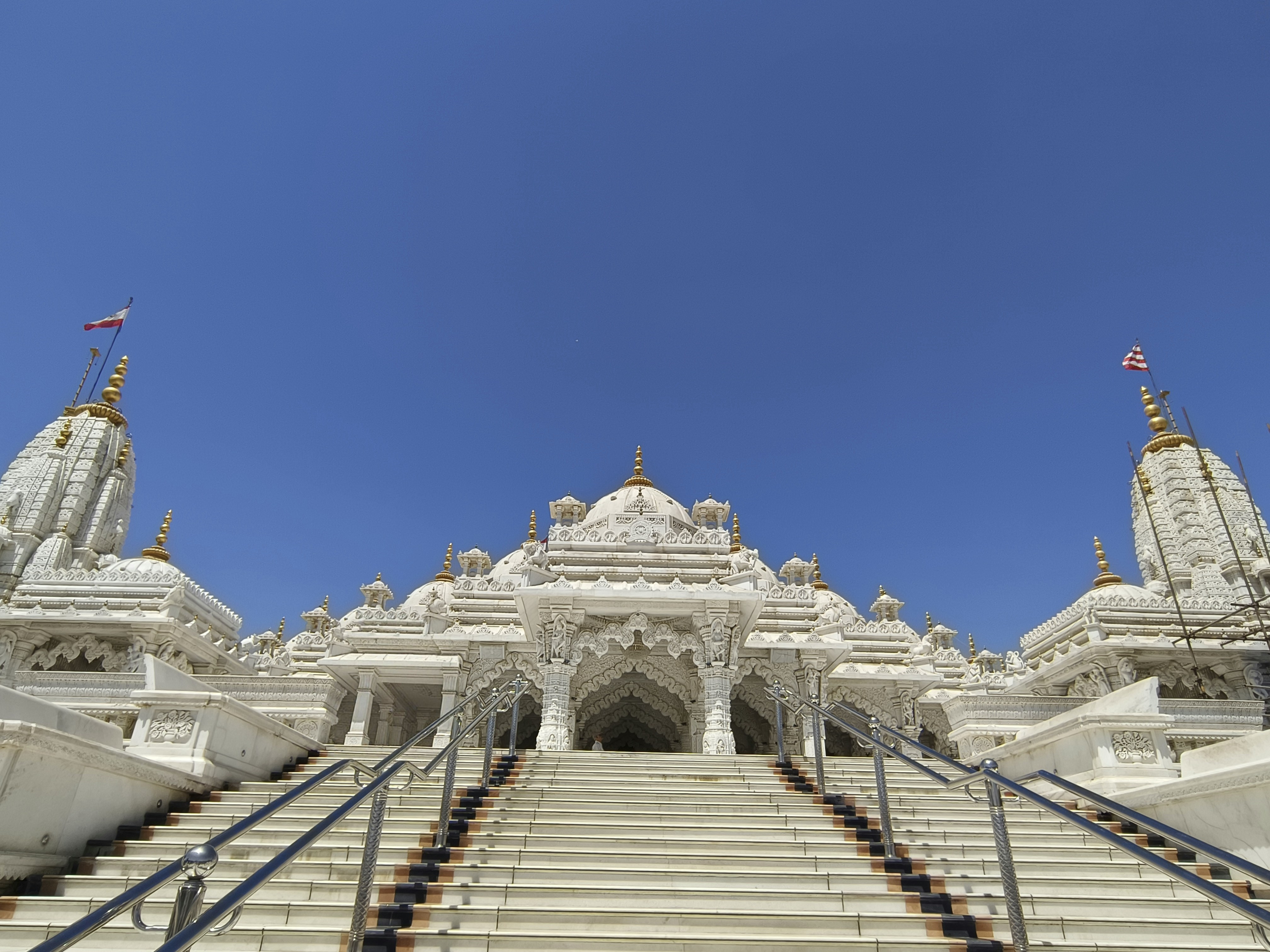 Ornate templescape: steps to a sunlit white pavilion