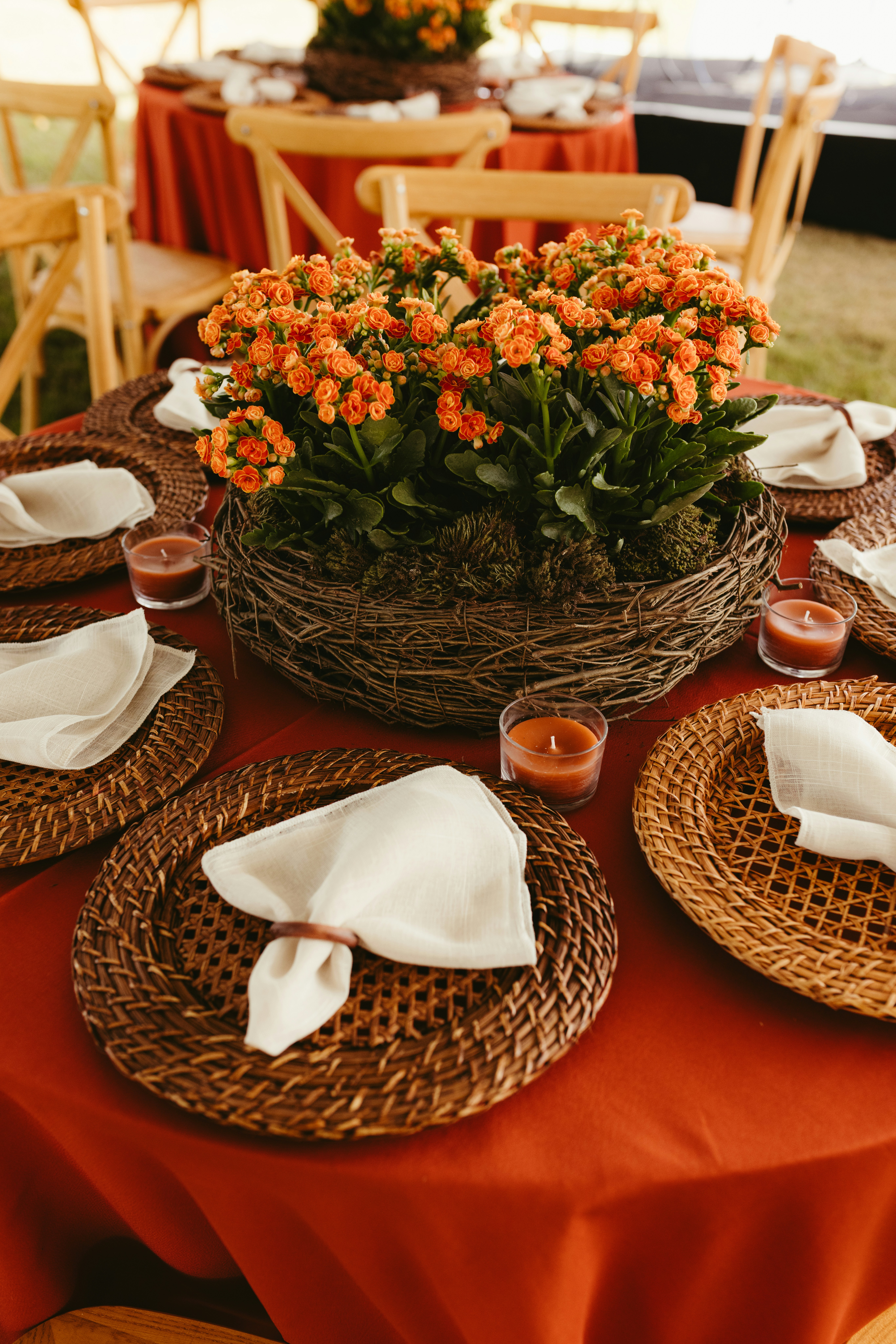 Autumnal centerpiece: orange roses haloed by woven basket on a terracotta banquet