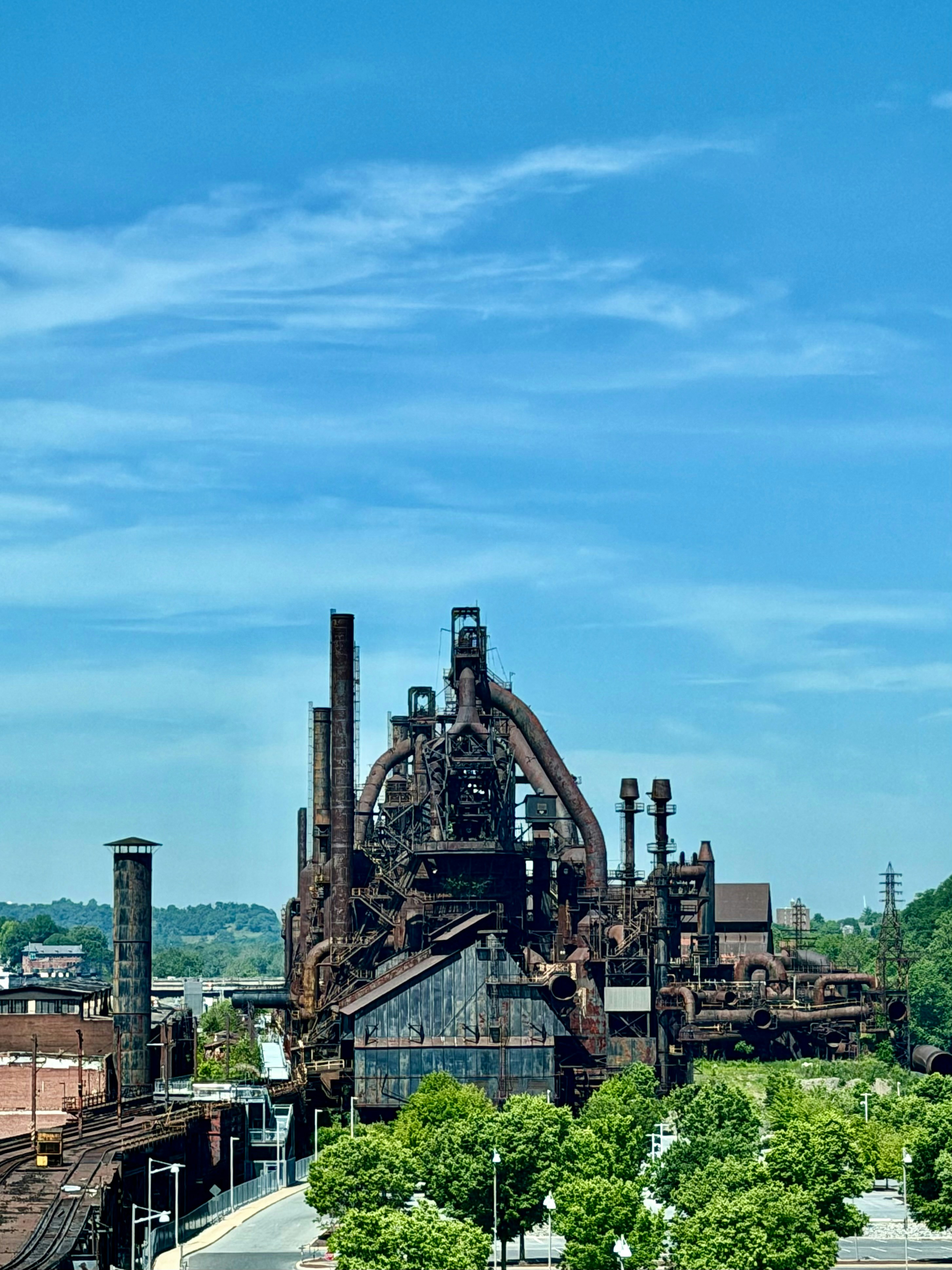 An old, rusty industrial complex under a blue sky.