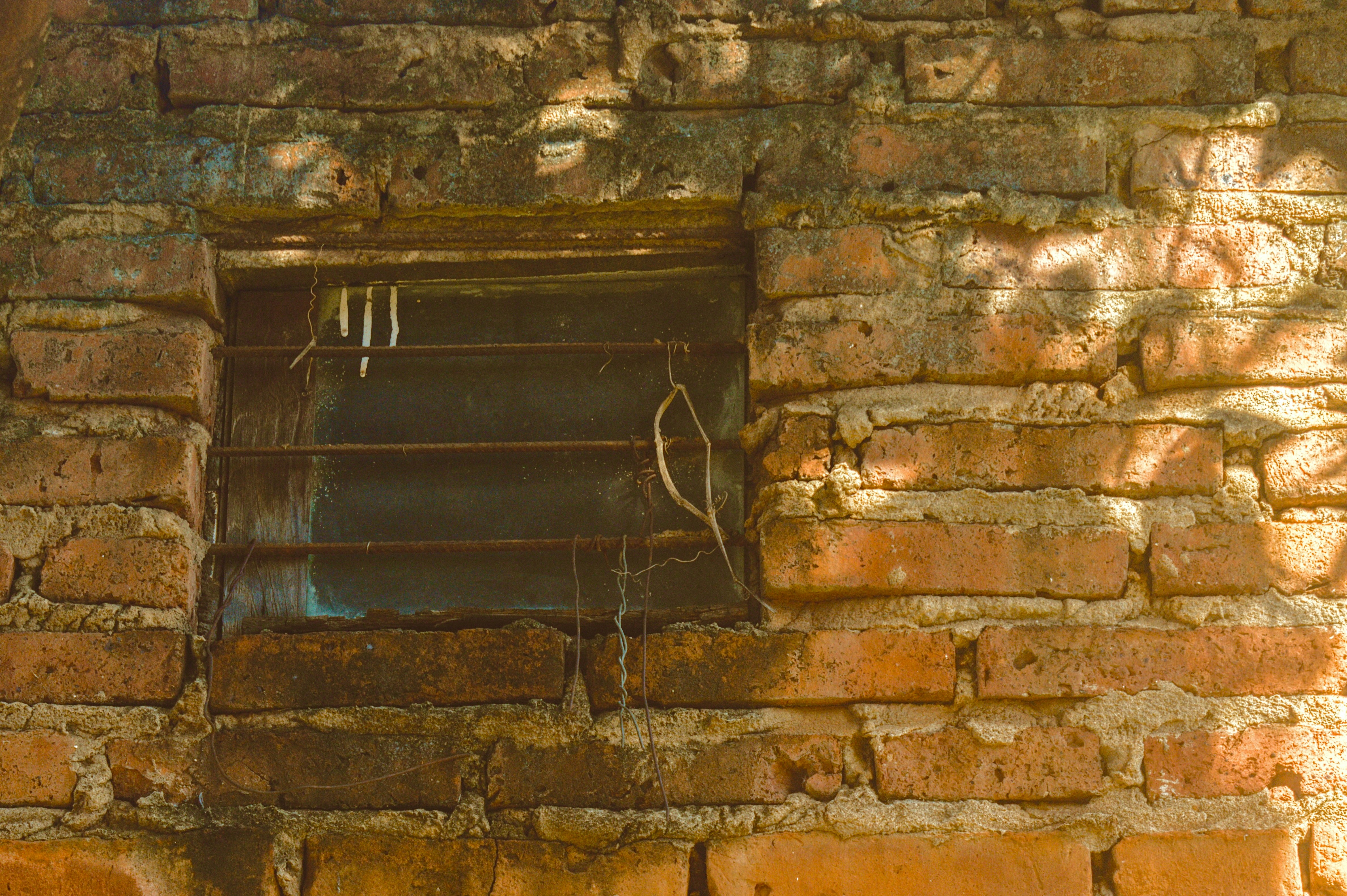 Weathered Window: Rust, Brick, and Hidden Threads