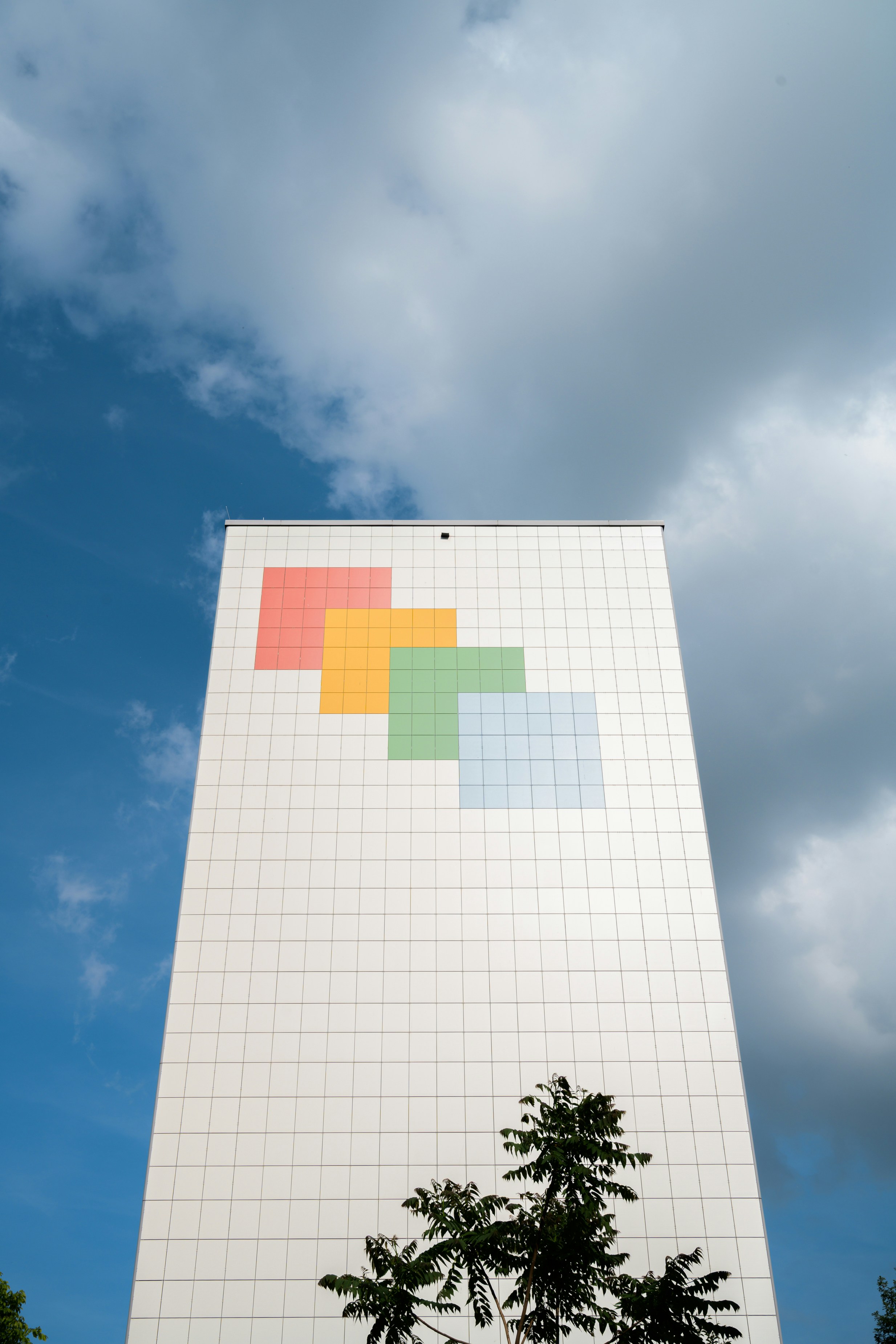Polyglot Sky: Colorful Squares Adorn a Tall Facade