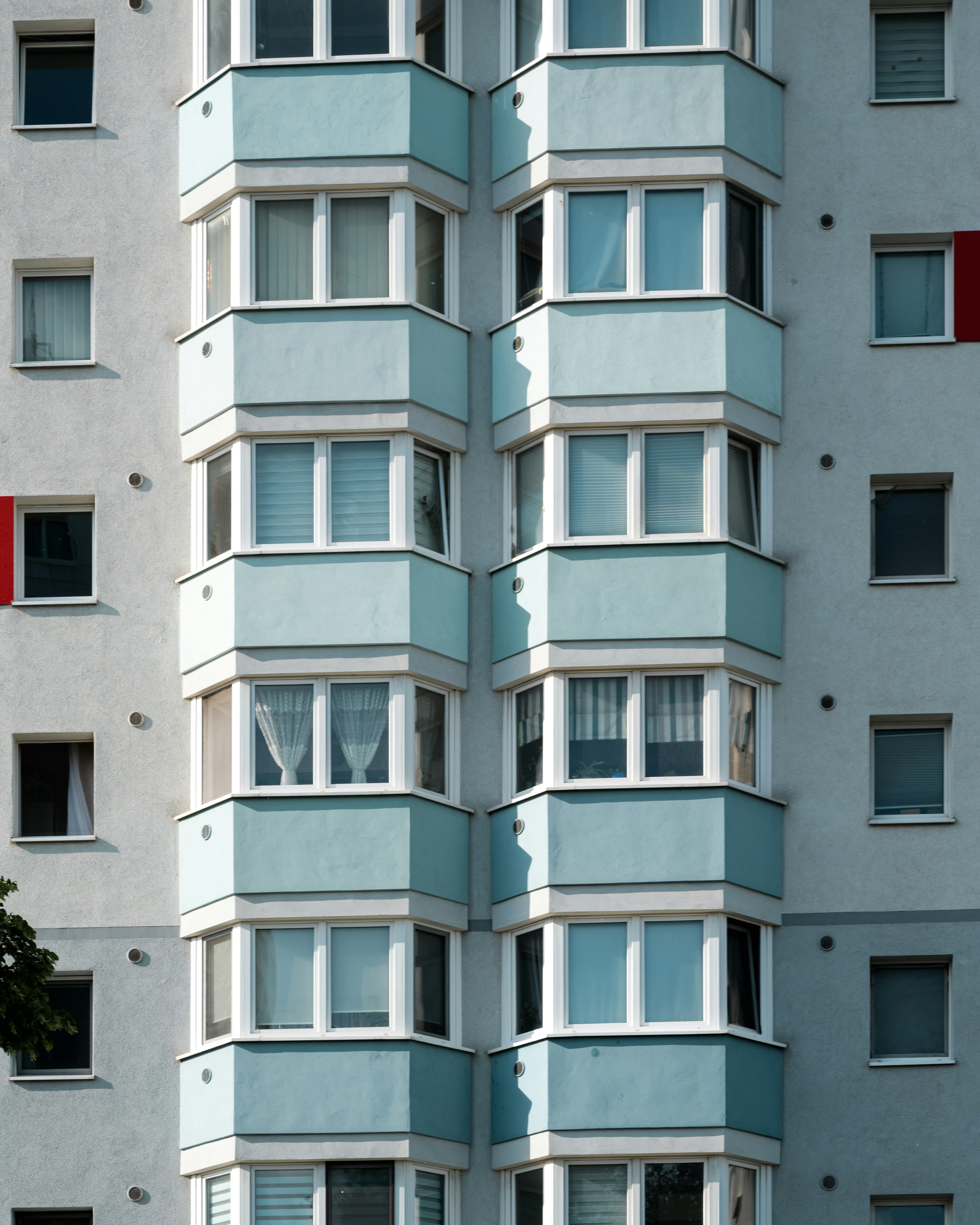 Aqua-tinted balconies marching up the concrete façade