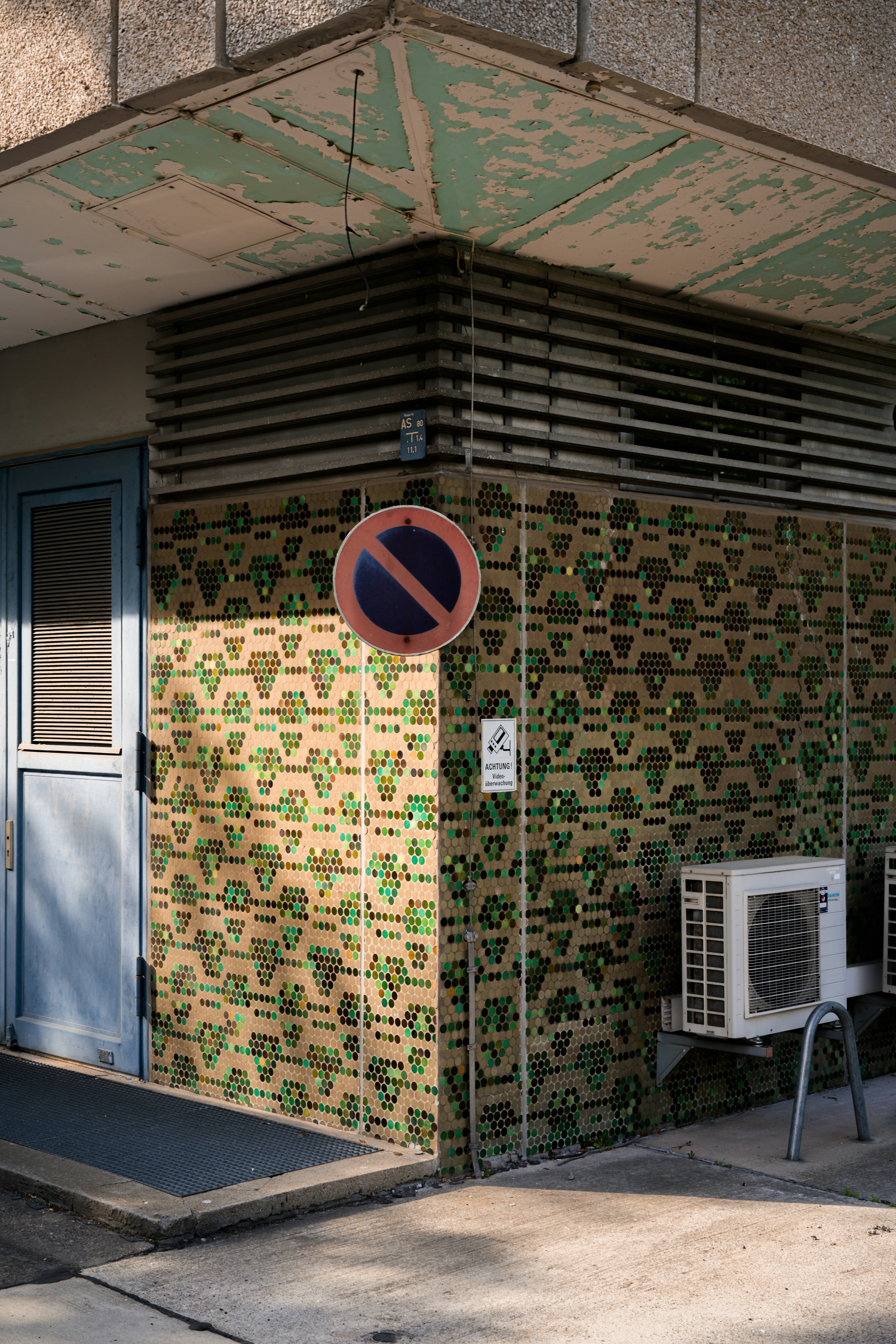 Corner Store Mosaic: A Quiet Urban Facade with a No-Parking Sign