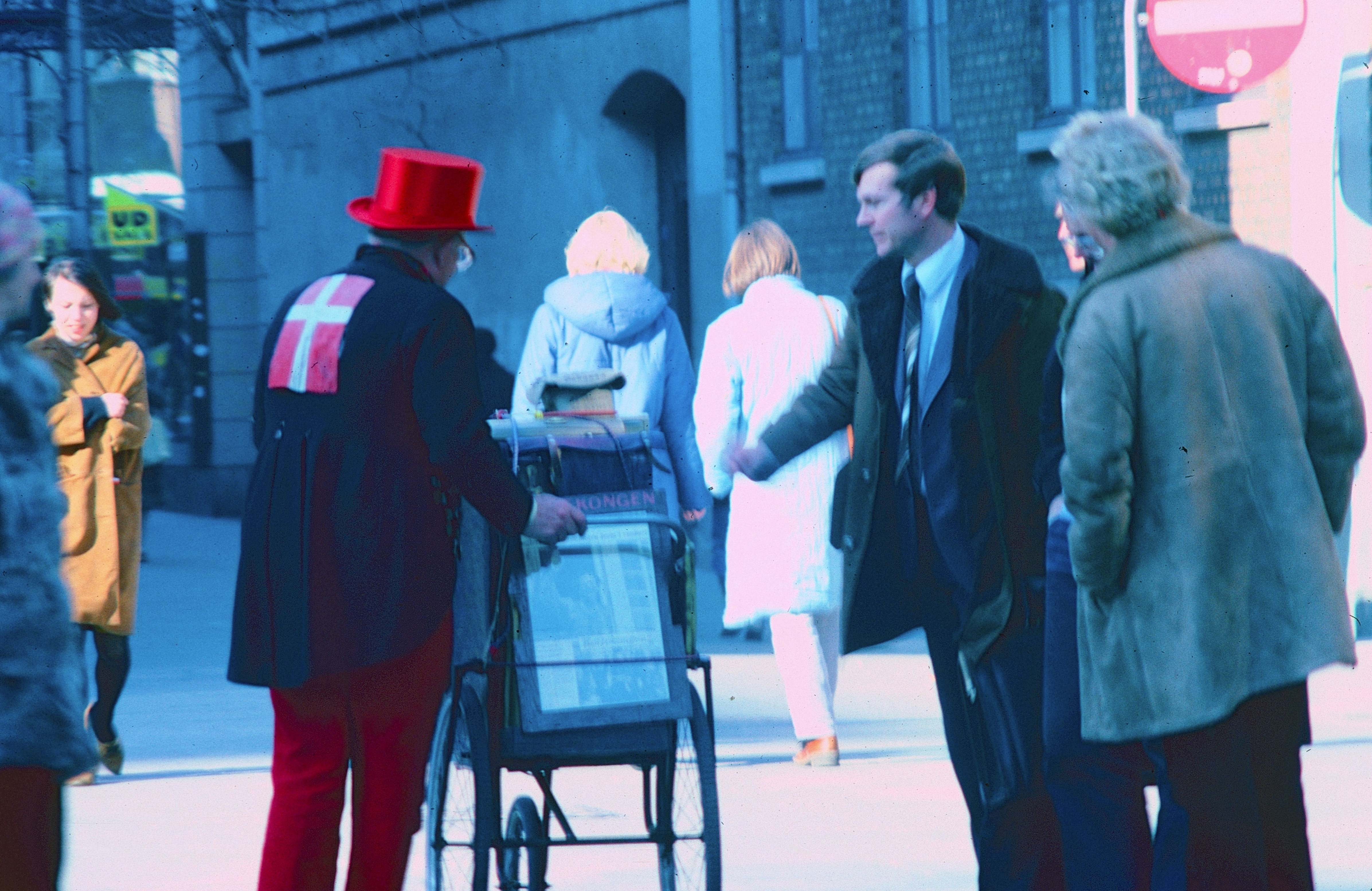 Street Shifts: A Red-Hatted Vendor amid a Quiet Pedestrian Exchange