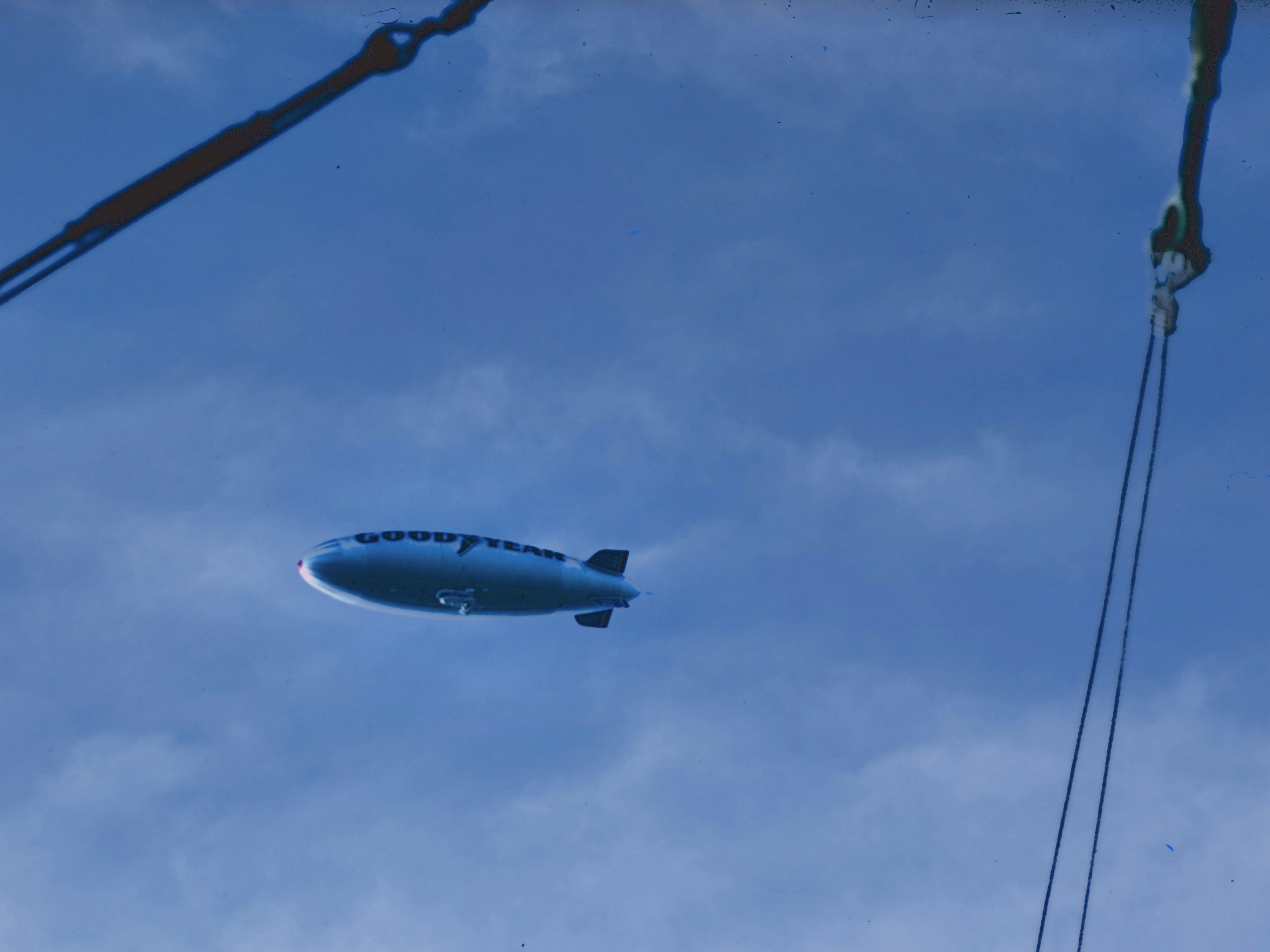 Airship in Blue: A Narrow Skyward Glimpse
