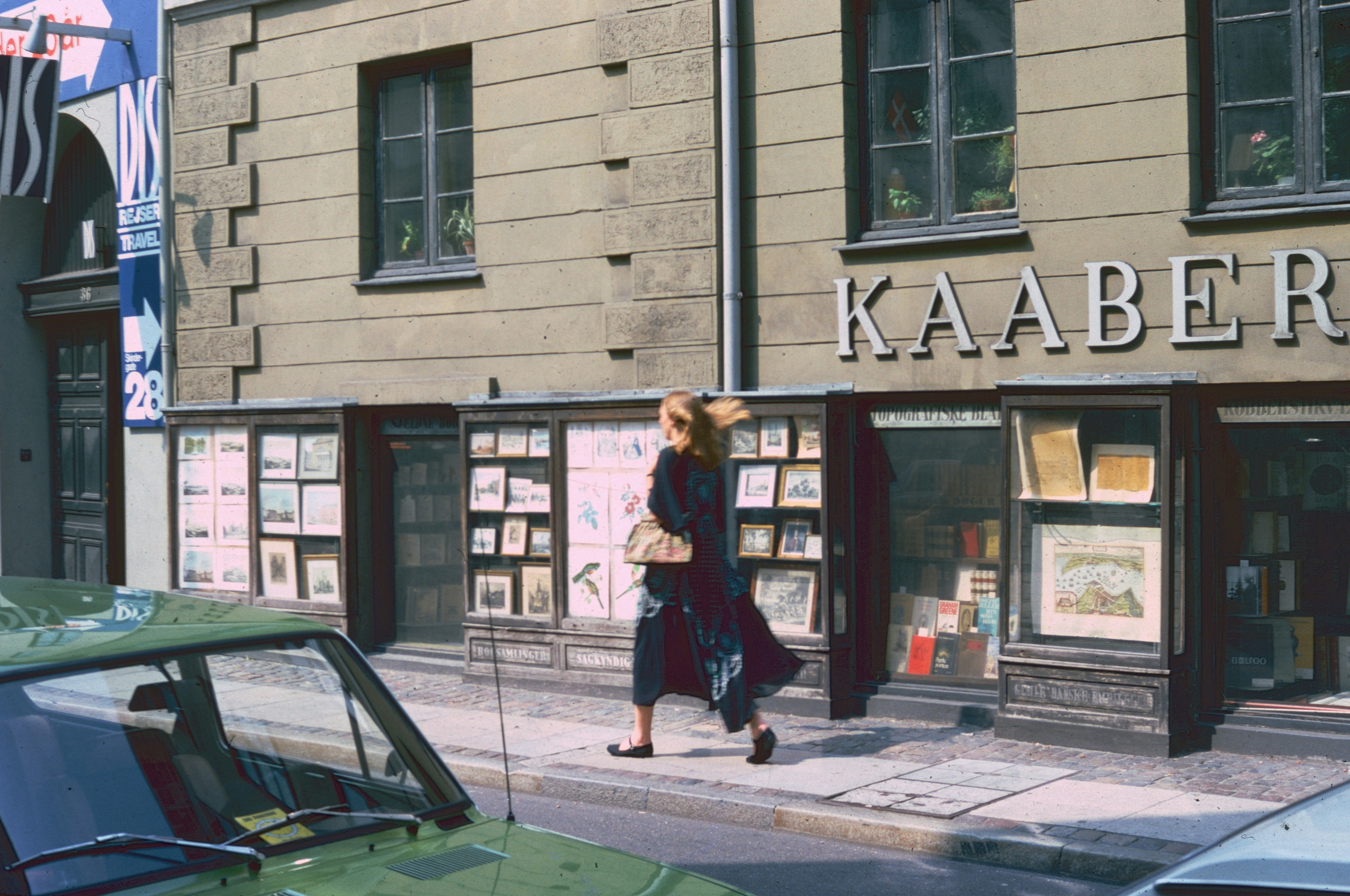 Pedestrian Crossing a Historic Shopfront on a Sunny City Street