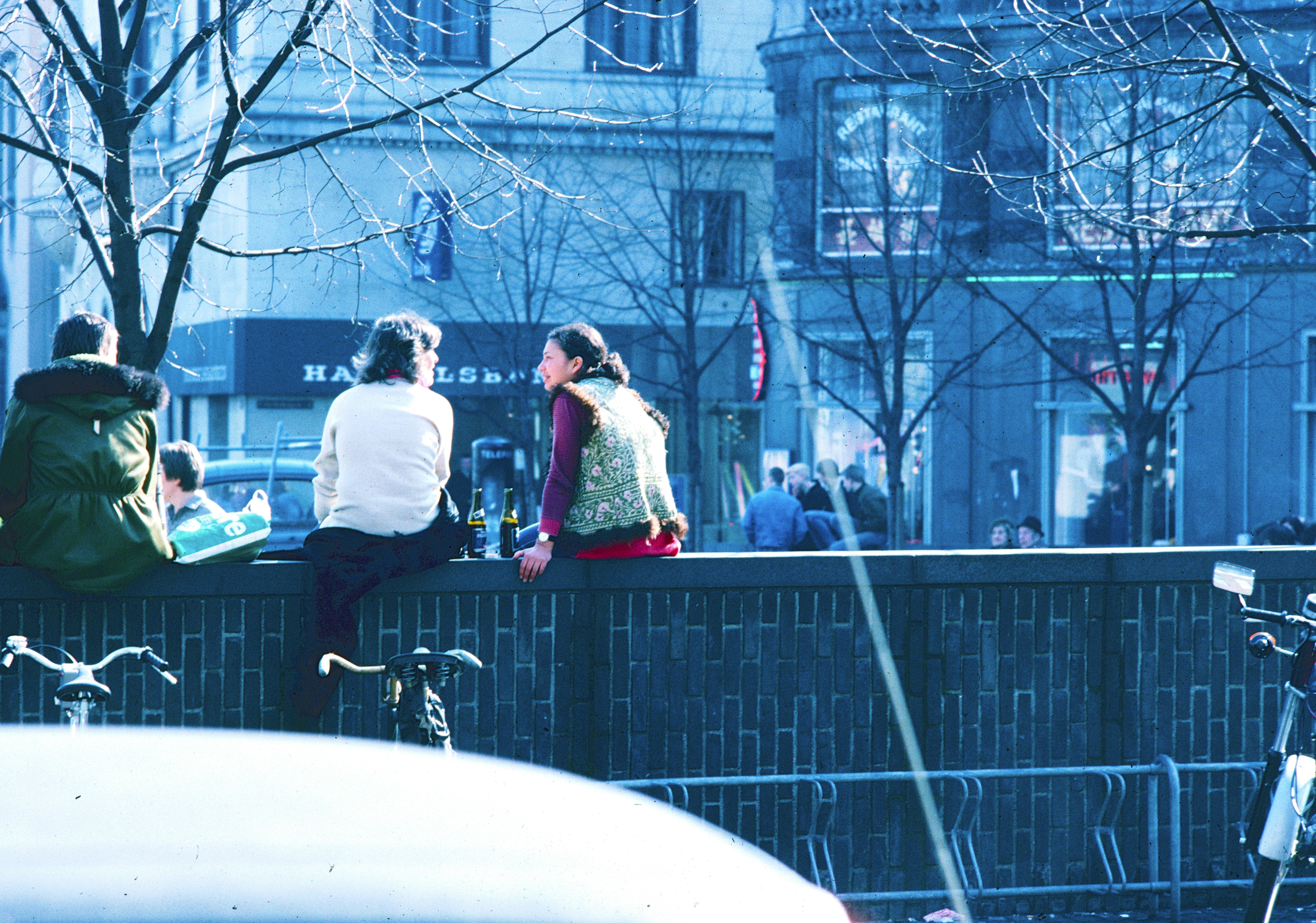 Rooftop Chat at Dusk: Two Friends on the Brick Barrier
