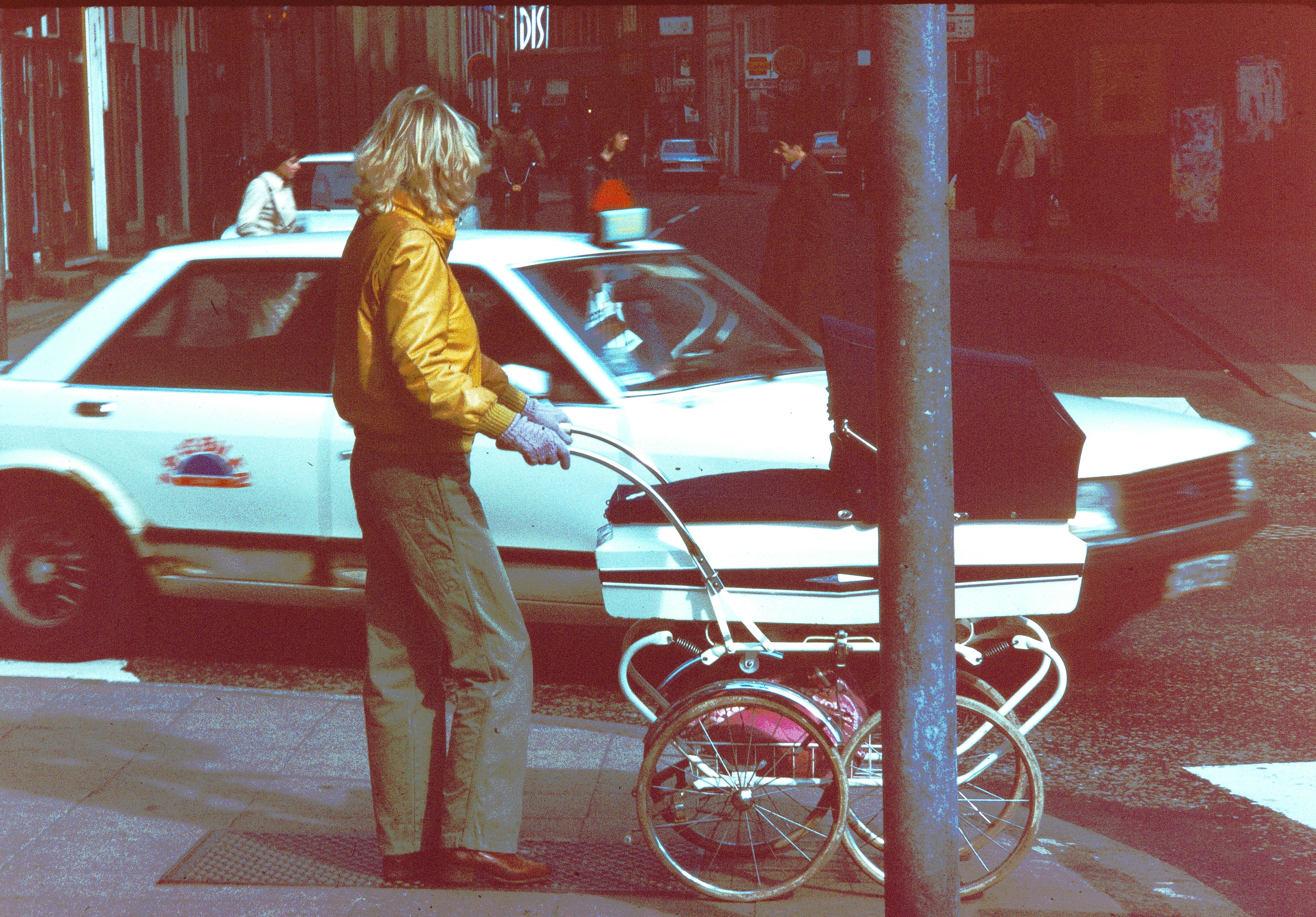 Pedestrian with Bicycle Under Red Shade on City Street
