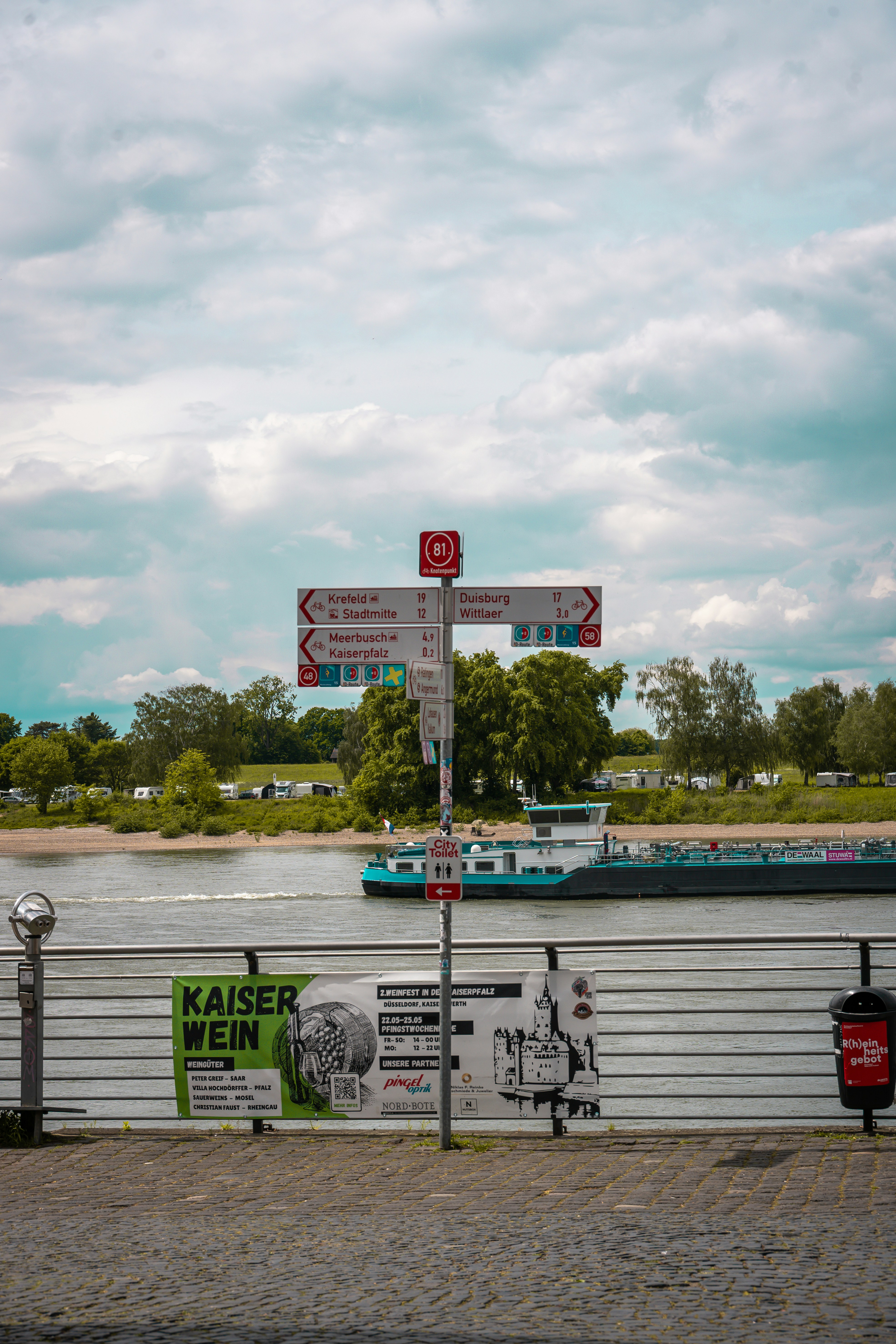 Signs by the River: A Quiet Ferry Stop Beneath Expansive Skies