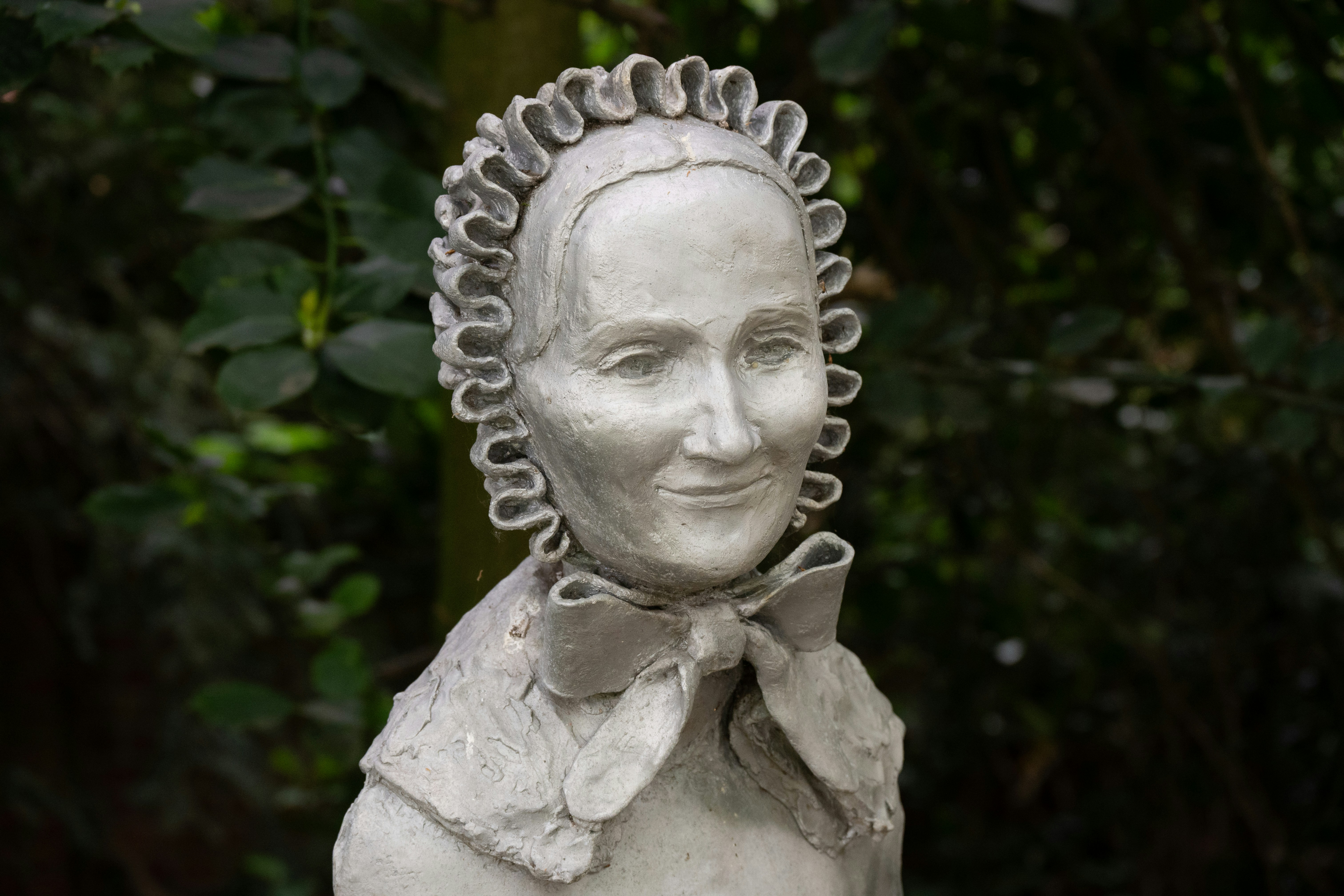 Smiling Gown and Frilled Hood: a Quiet Bust in the Garden