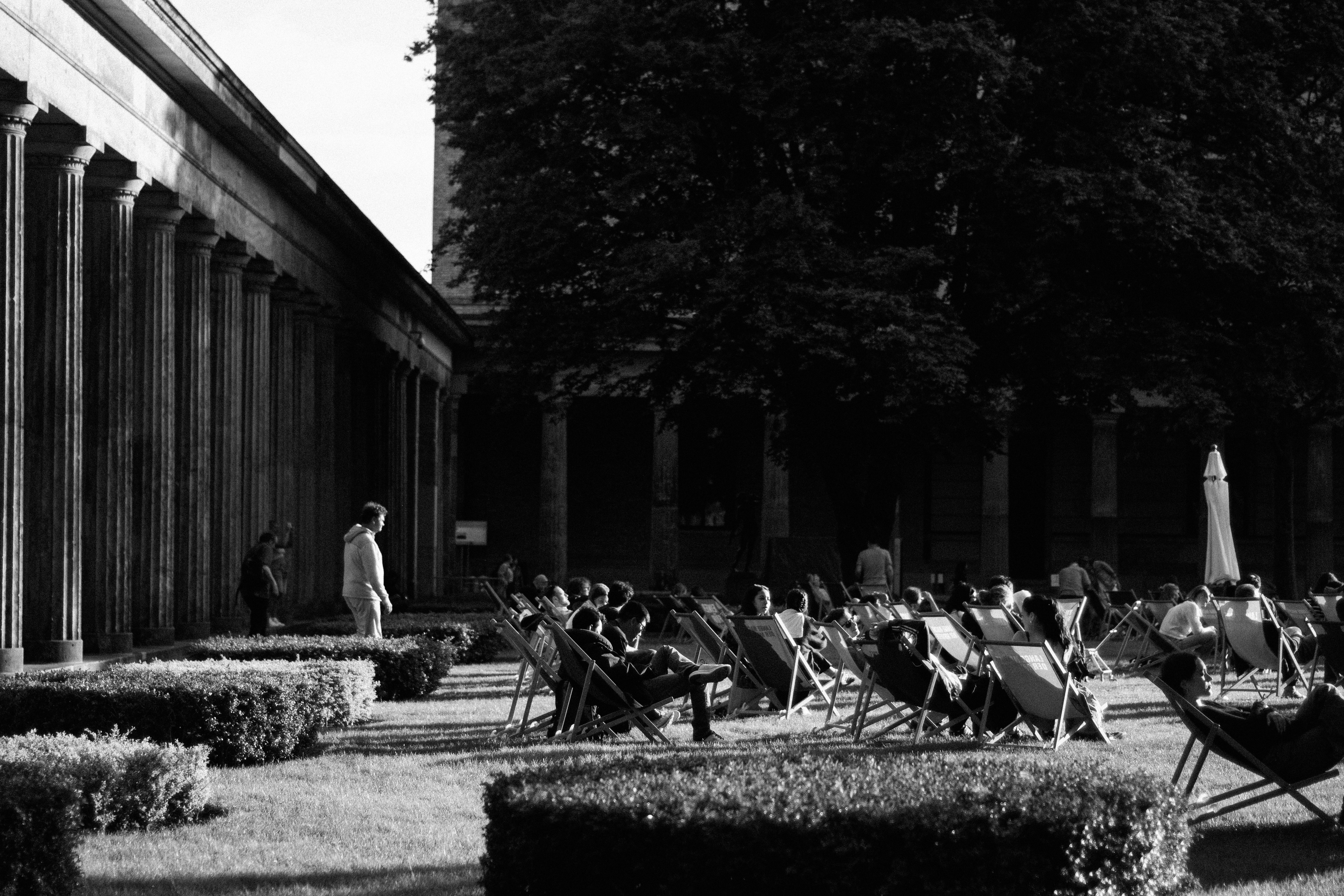 Silent Audience: Rows of Lounge Chairs and a Lone Figure by the Colonnade