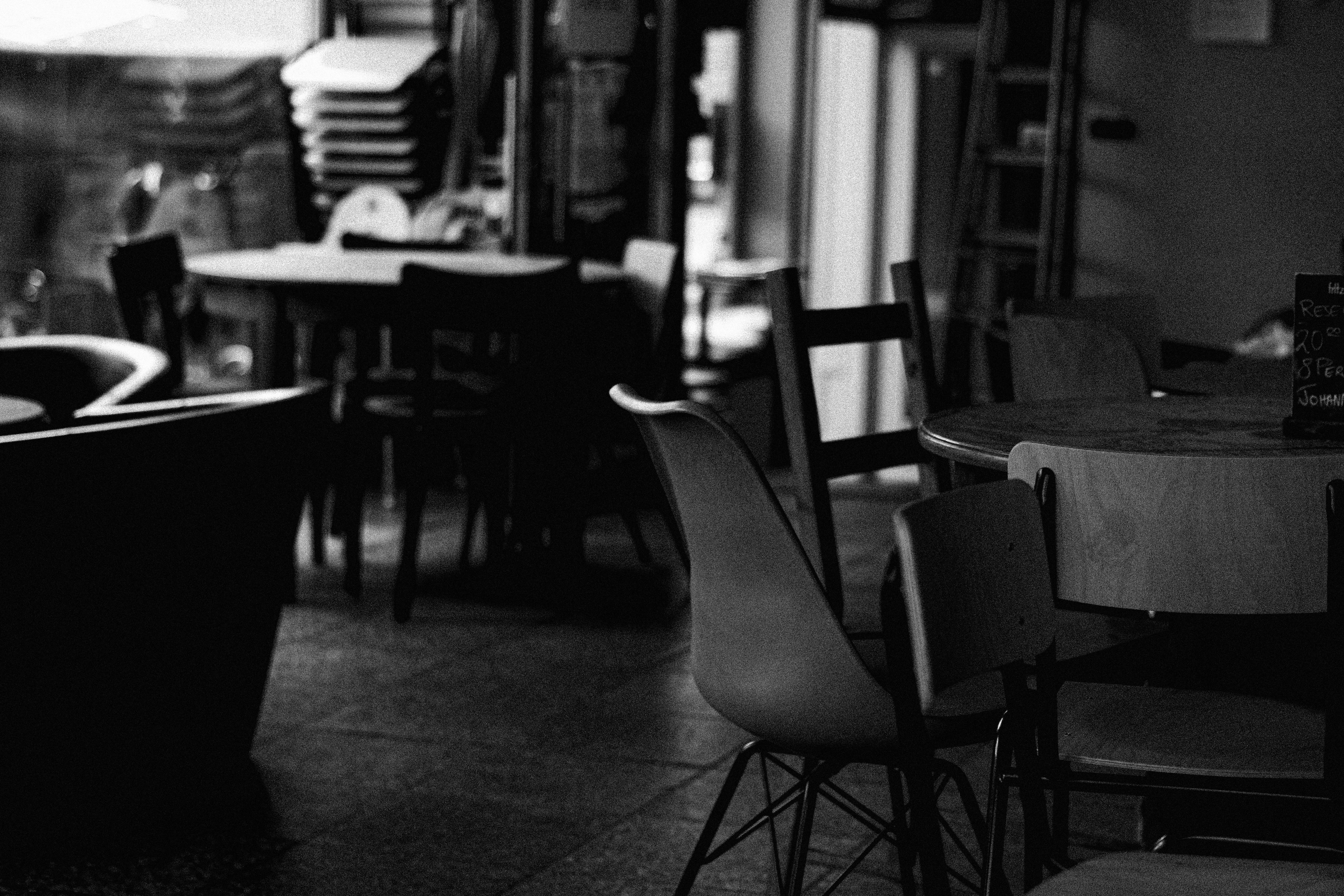 Monochrome cafe interior with vacant tables and chairs.