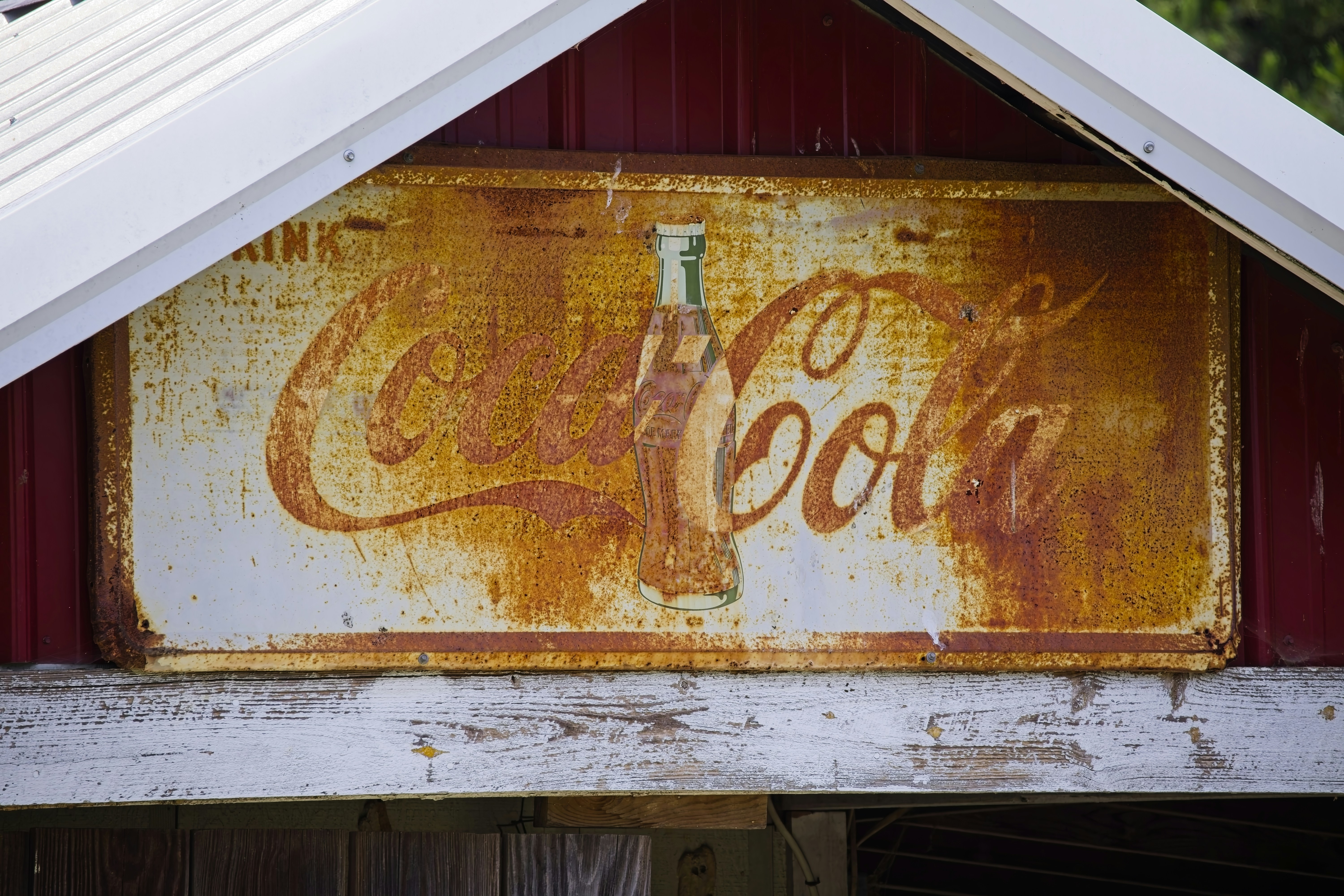 Rusty Coke Sign Under a Weathered Gable