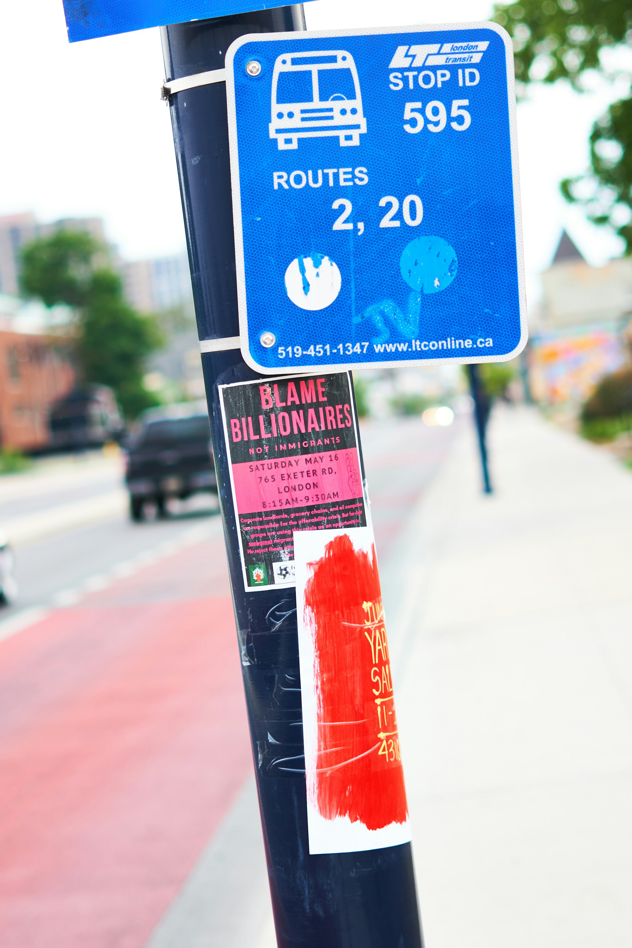 Bright Bus Stop Sign & Posters on a Street Pole