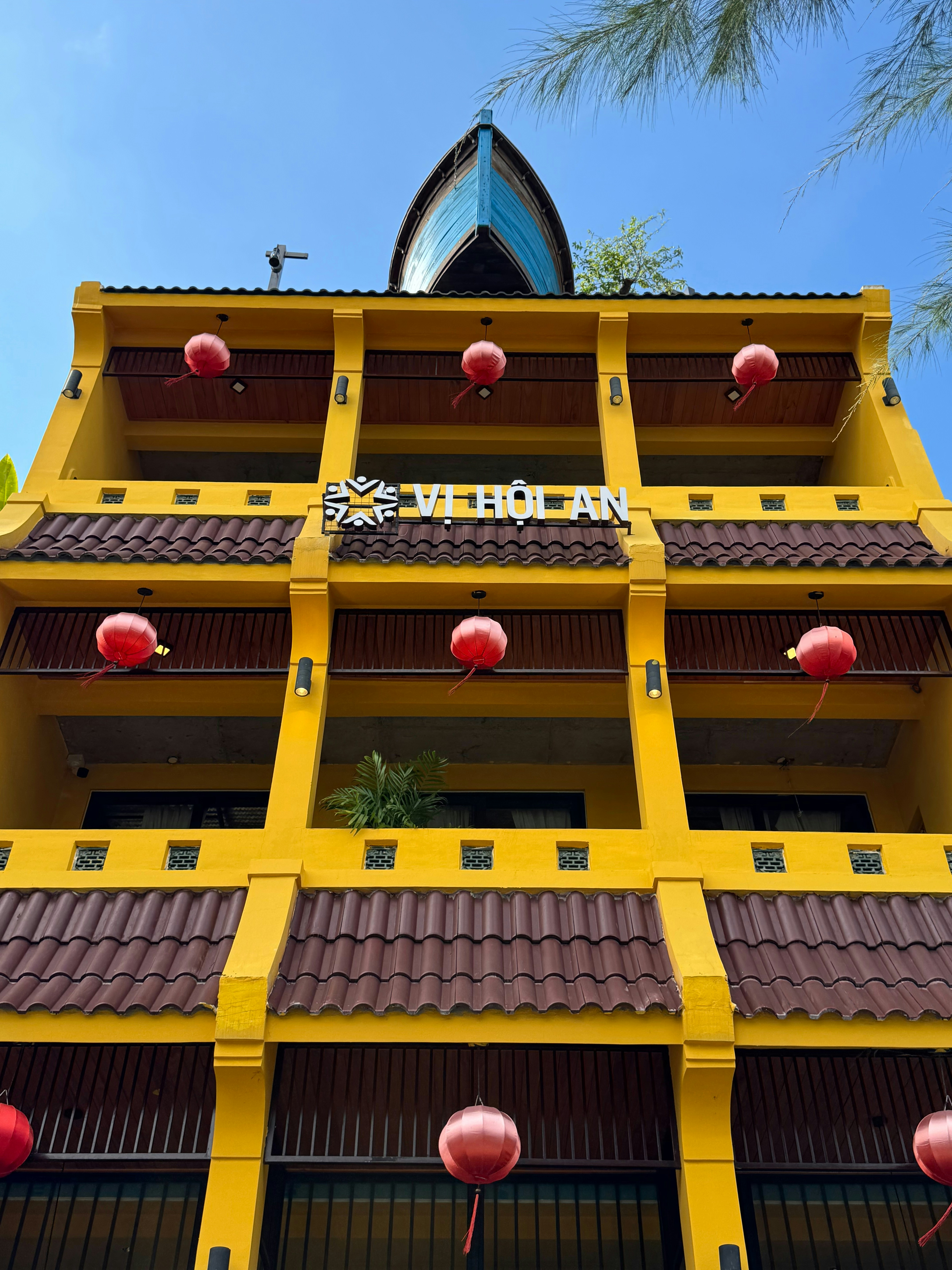 Vibrant Yellow Facade with Floating Red Lanterns under a Sky-arched Roof