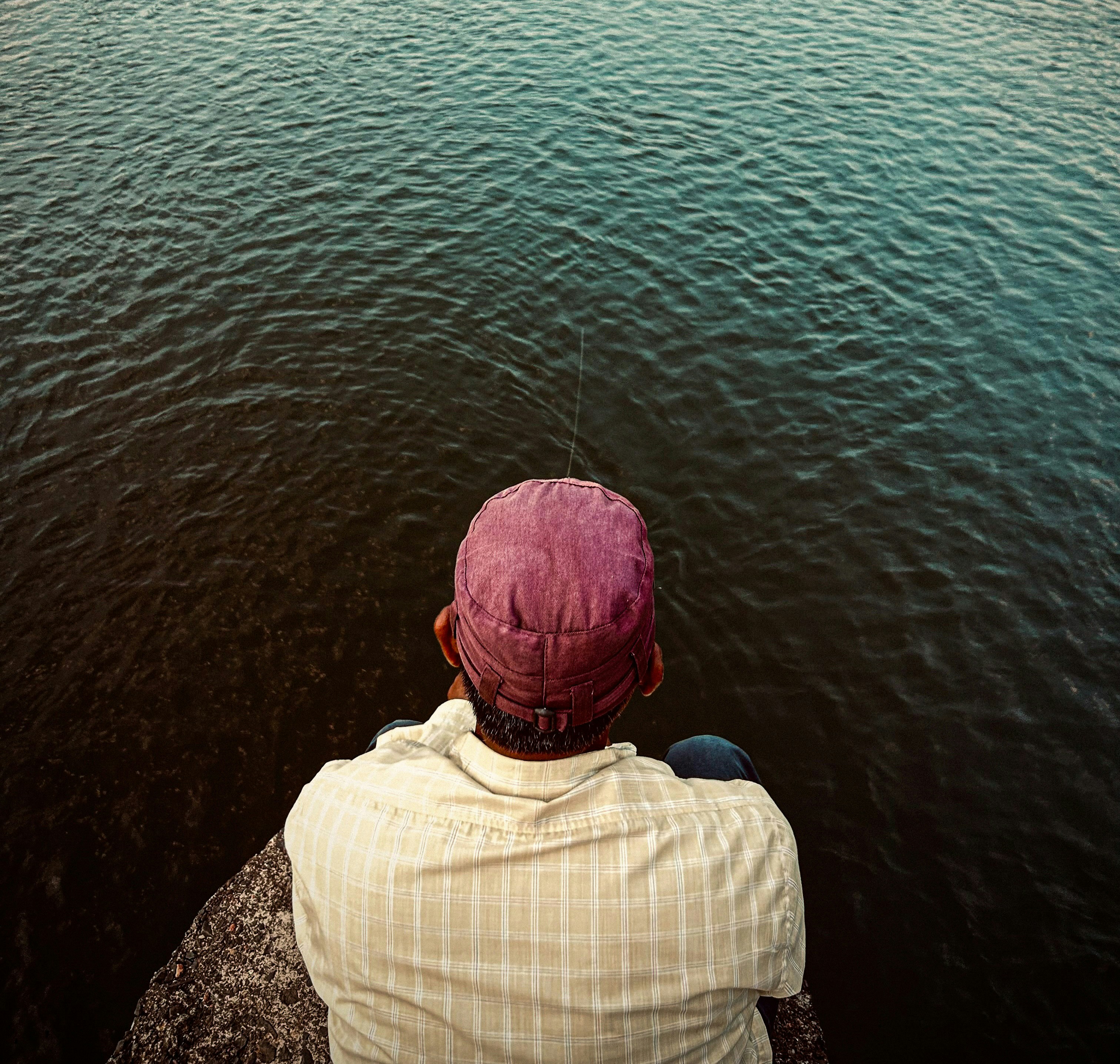 Over the Edge: A Fisherman’s Quiet Pause at Dusk