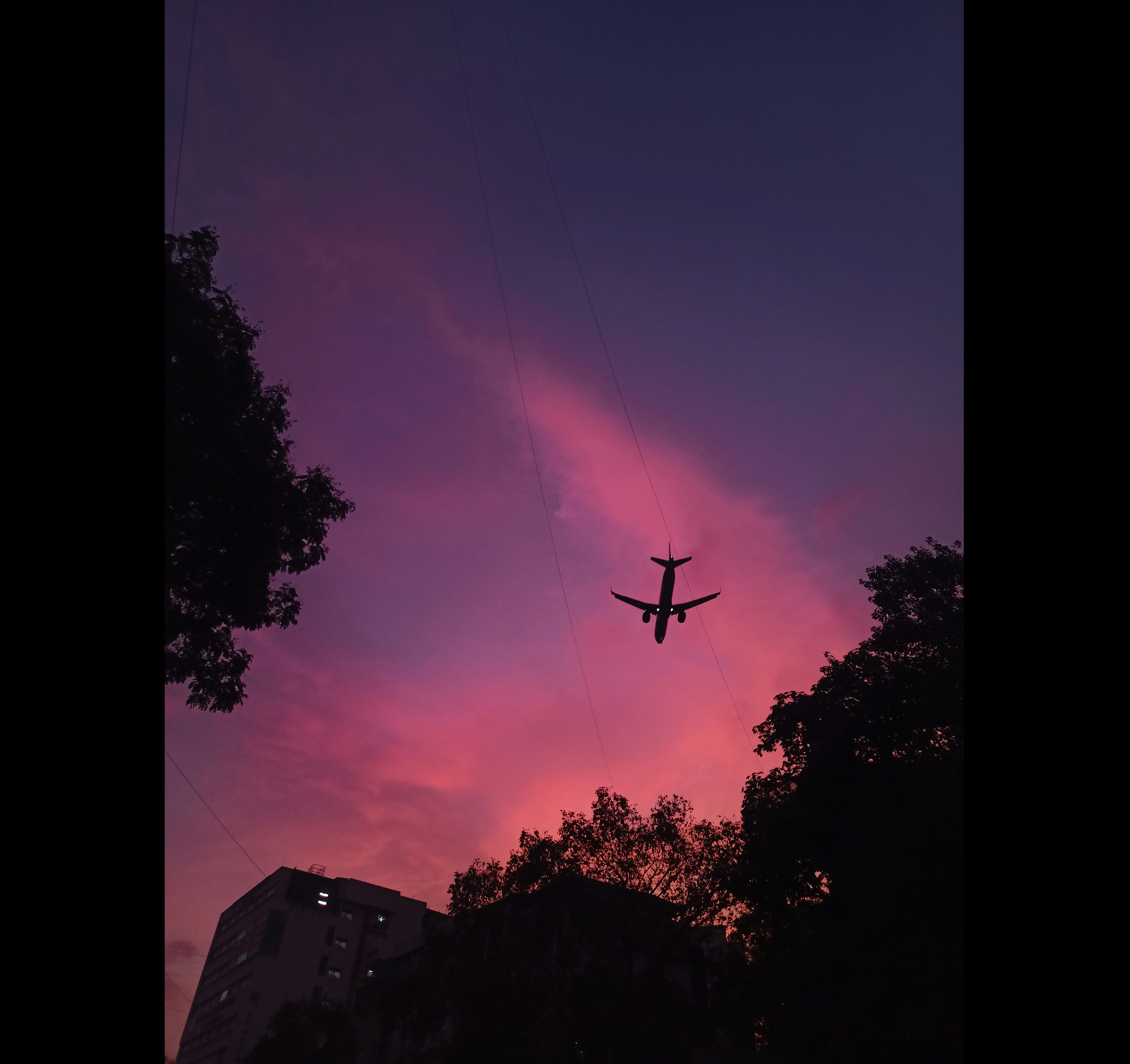 Jet silhouettes through a pink twilight sky