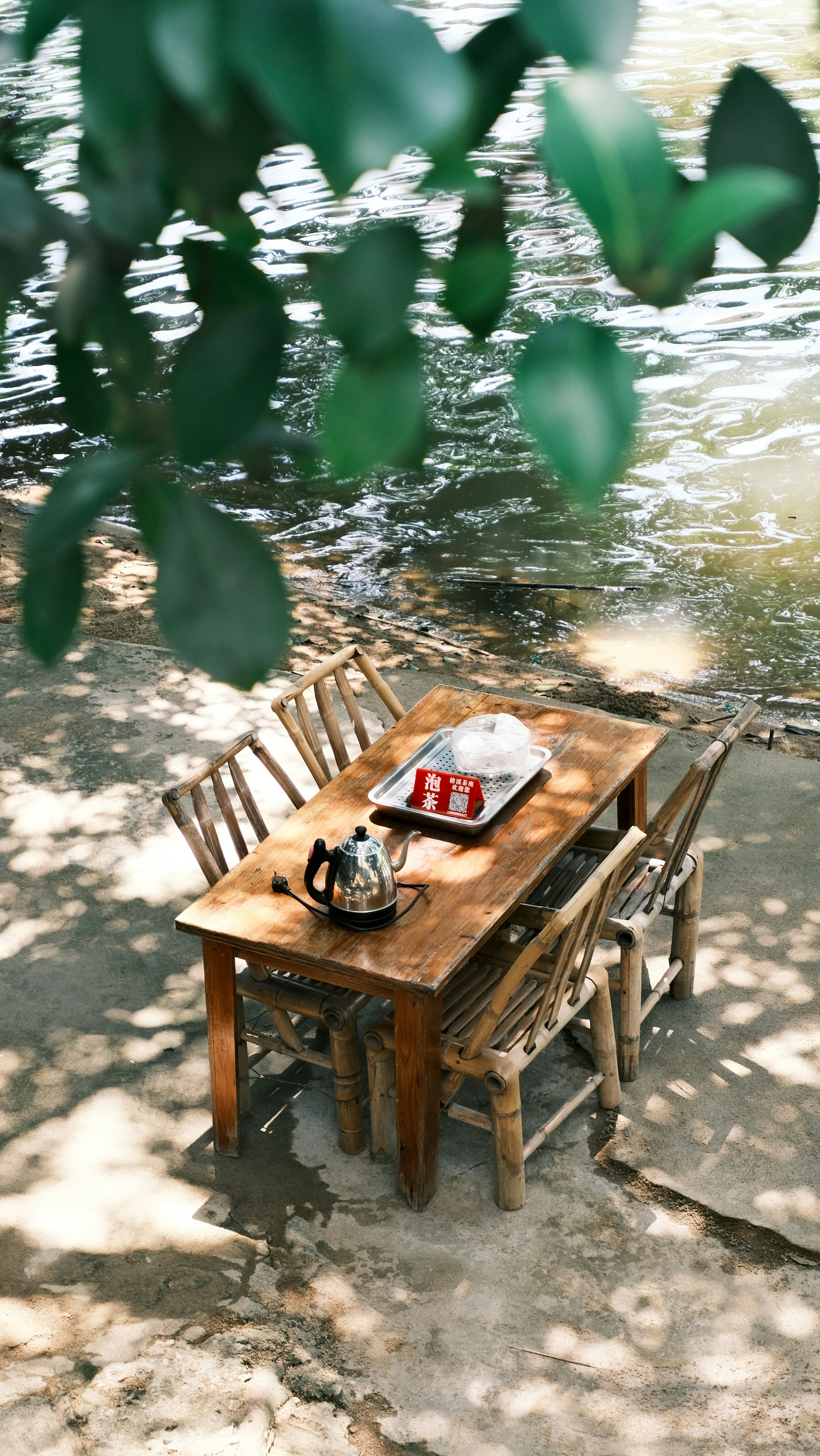 Tea Time Outdoors: A Wooden Table Set Amid Dappled Shade